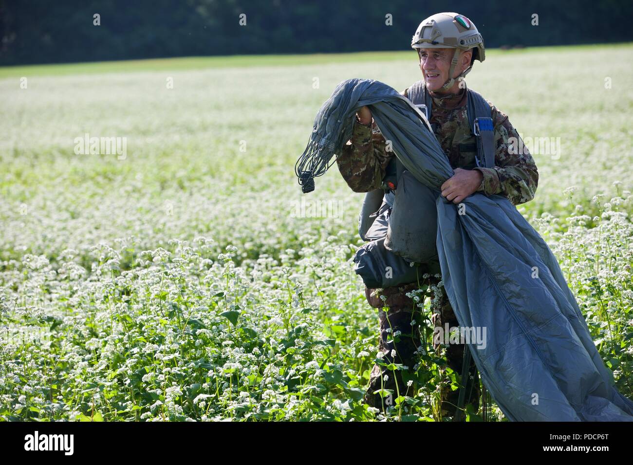 A Italian Paratroopers packs up his MC-6 parachute on Castle Drop Zone ...
