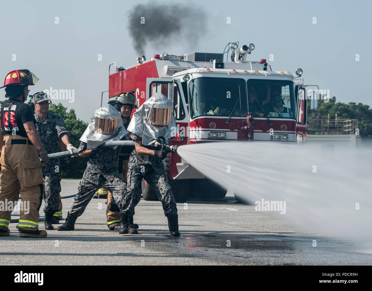 Members from the Naha Air Base fire department test the force of water ...