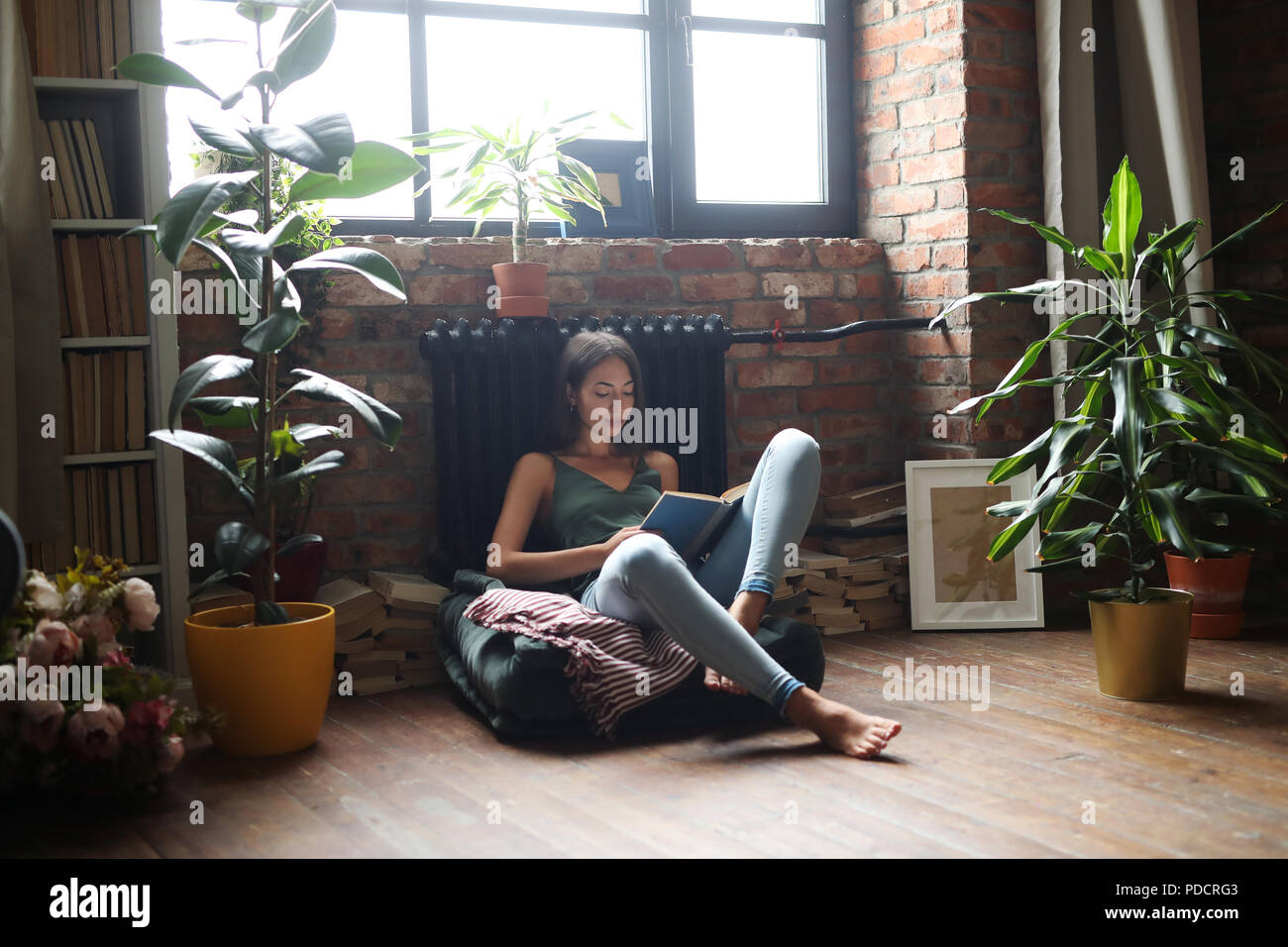 Student. Woman with book on the floor Stock Photo - Alamy