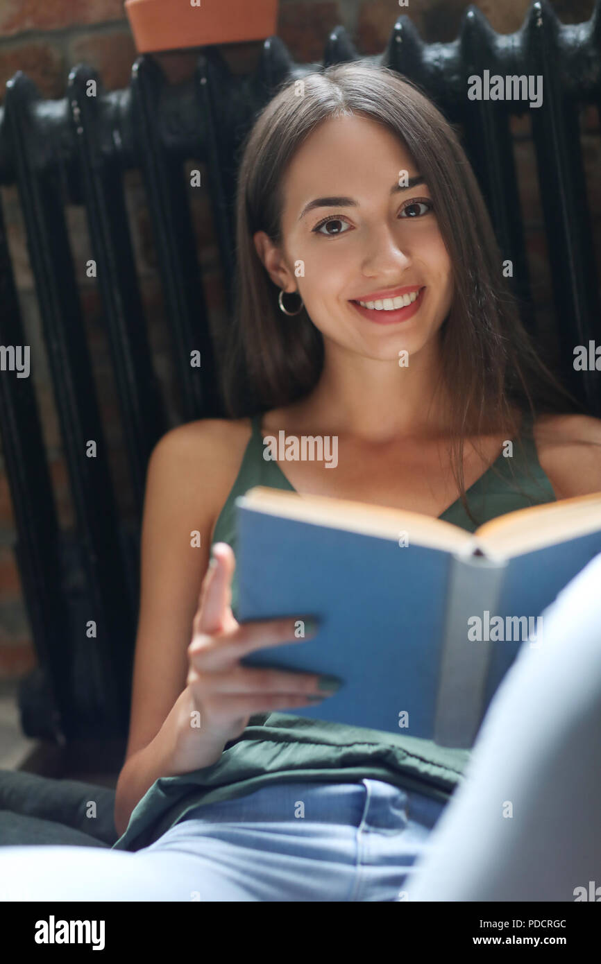 Student. Woman with book on the floor Stock Photo - Alamy