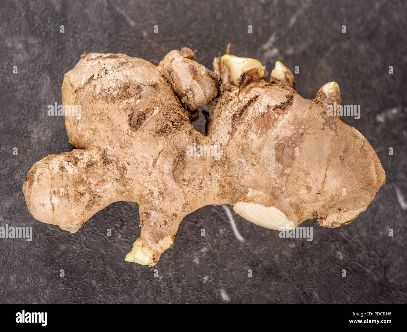 Whole ginger roots on dark old stone background table, space for text ...