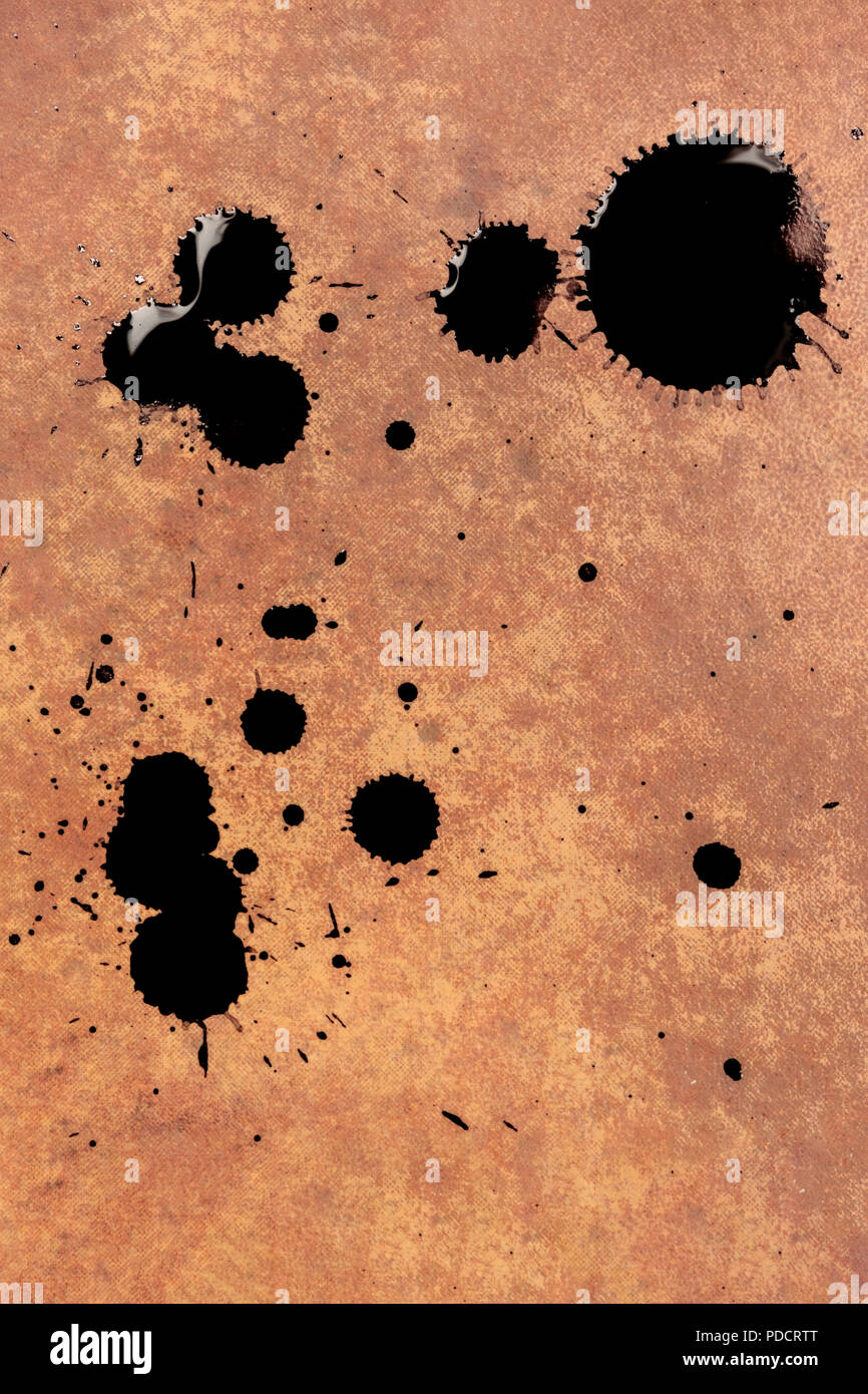 A splash of black ink on a brown texture, a grunge background with copy ...