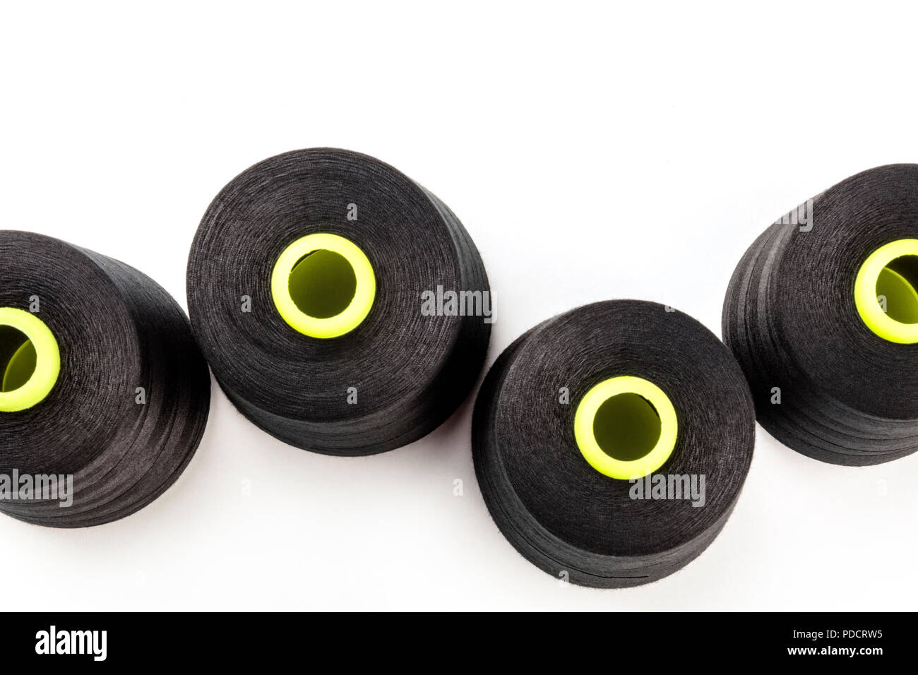 An overhead photo of several large black thread spools, shot from above ...