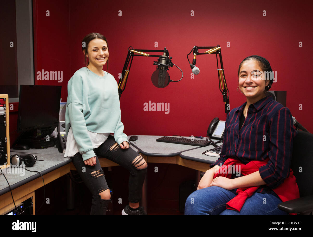 Portrait confident teenage girl musicians recording music in sound ...