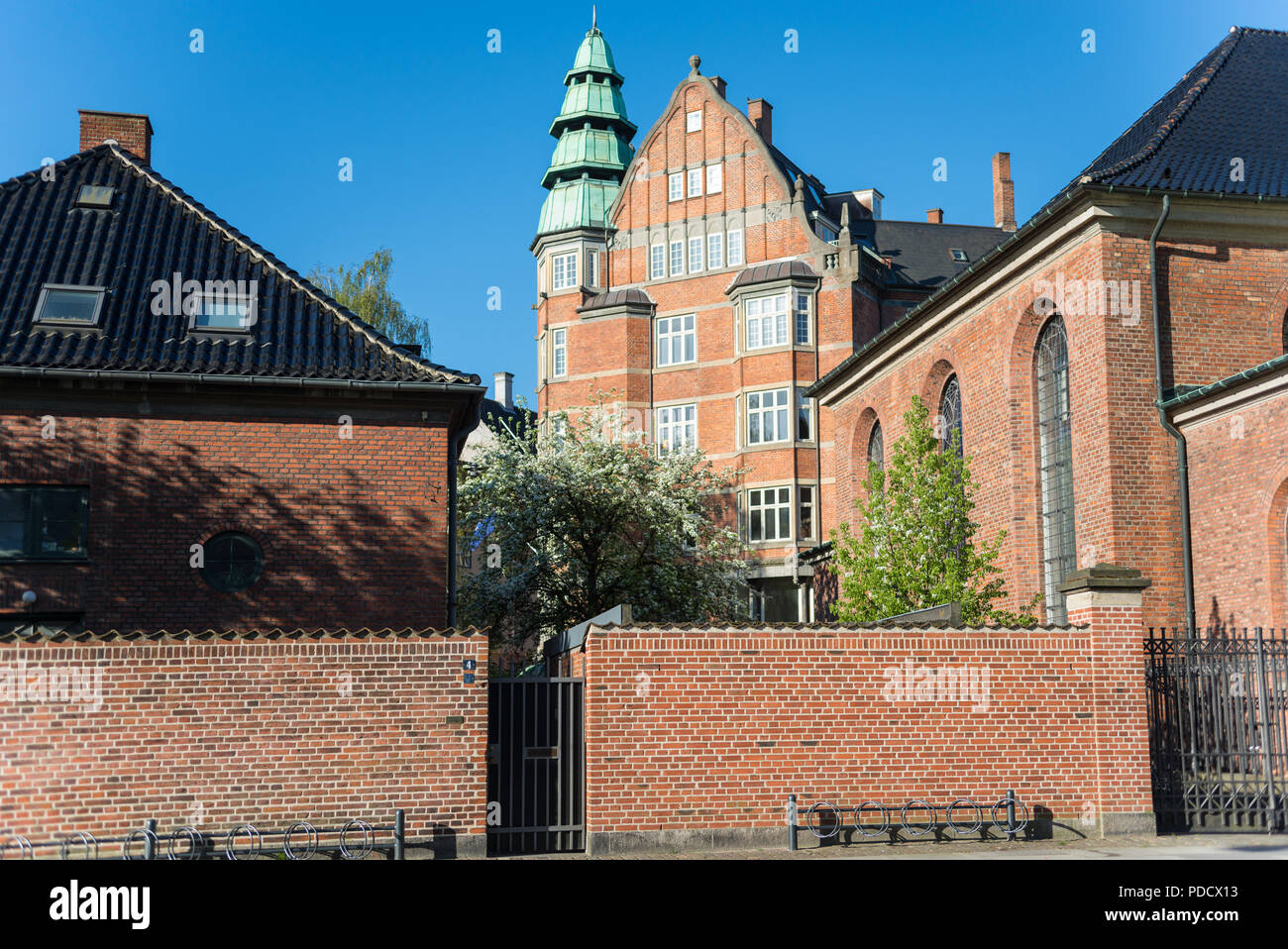 brick wall, church and houses at sunny day in copenhagen, denmark Stock ...