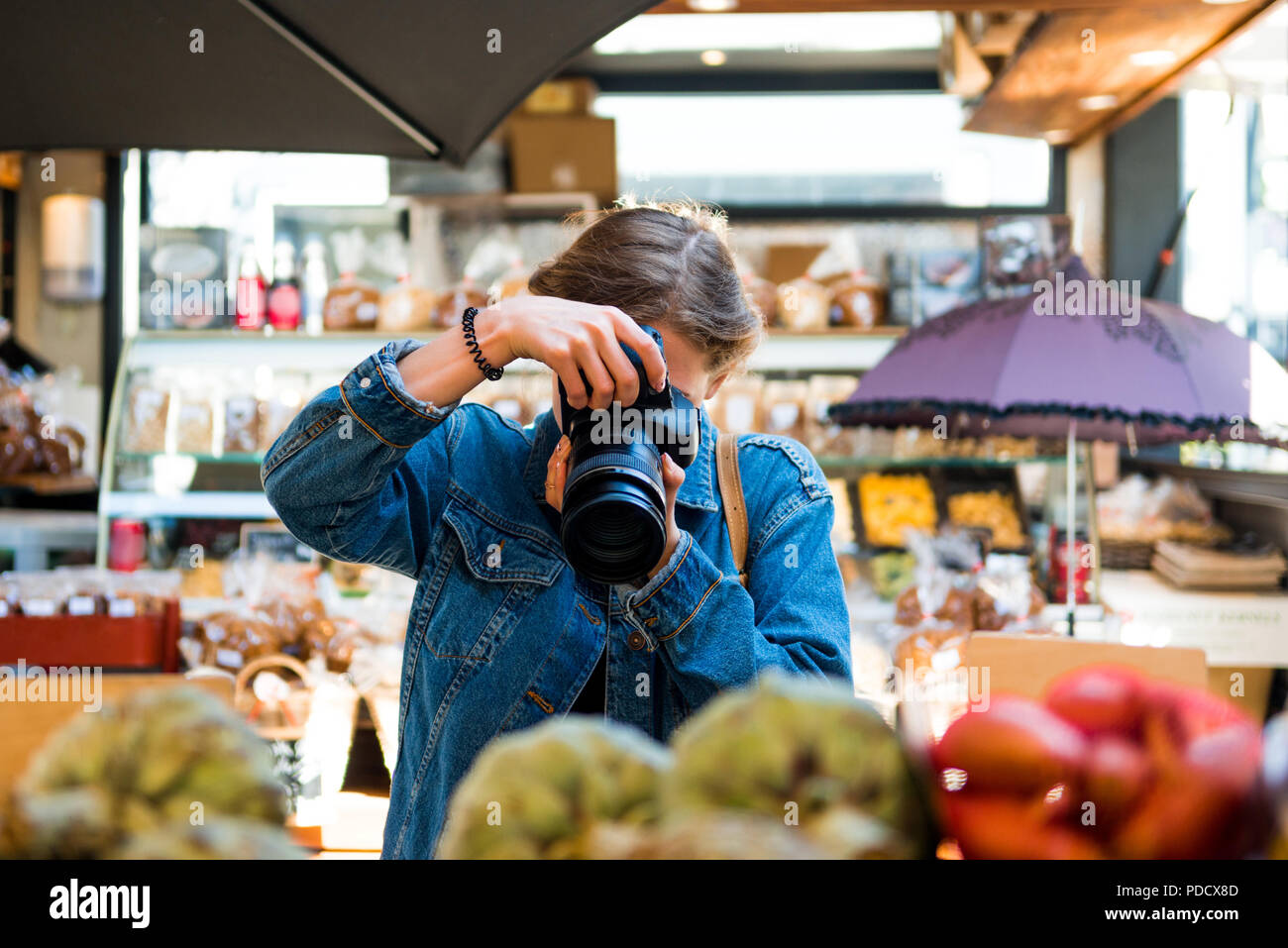 woman with obscured face by camera taking picture in shop Stock Photo ...
