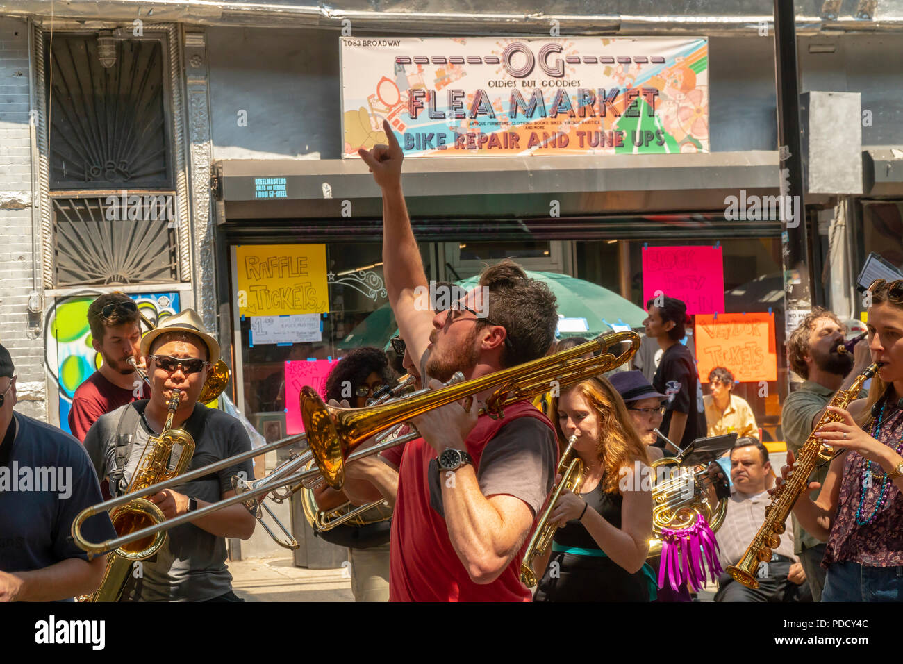 The "L Train Brass Band" performs under the elevated train on Broadway ...