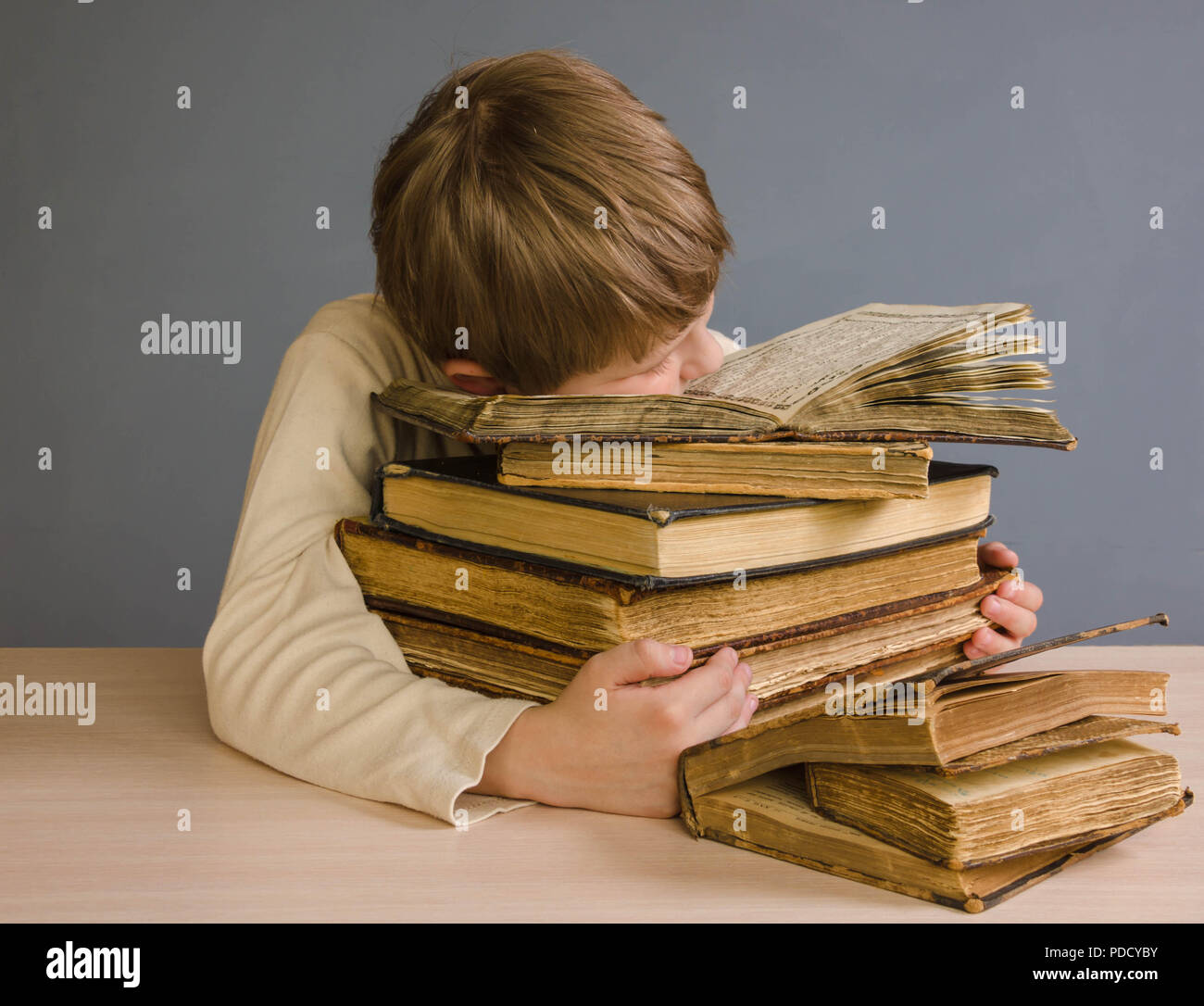 A boy is hugging a pile of books - a concept back to school Stock Photo ...
