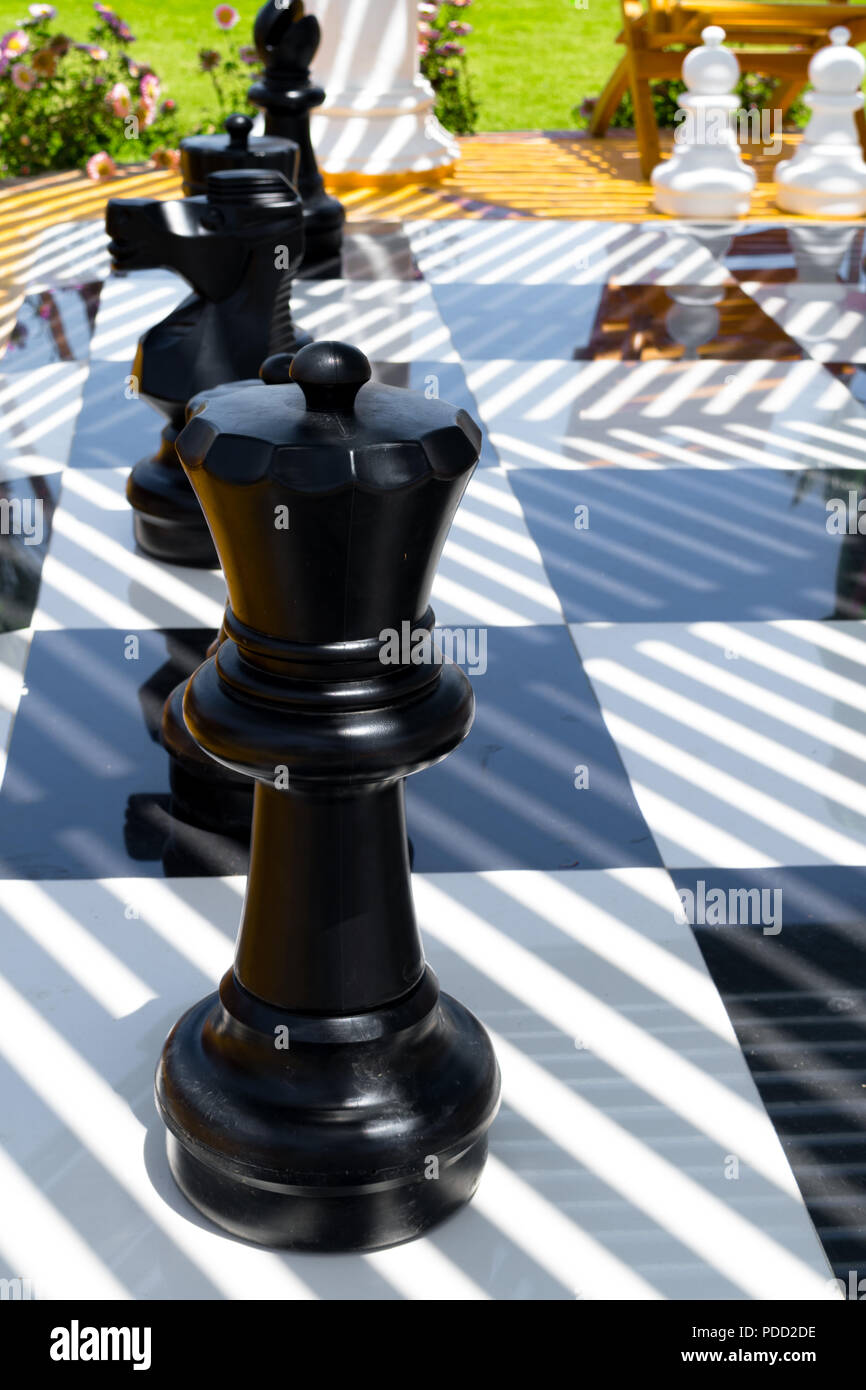 large Chess queen isolated on white and black board outdoor Stock Photo ...