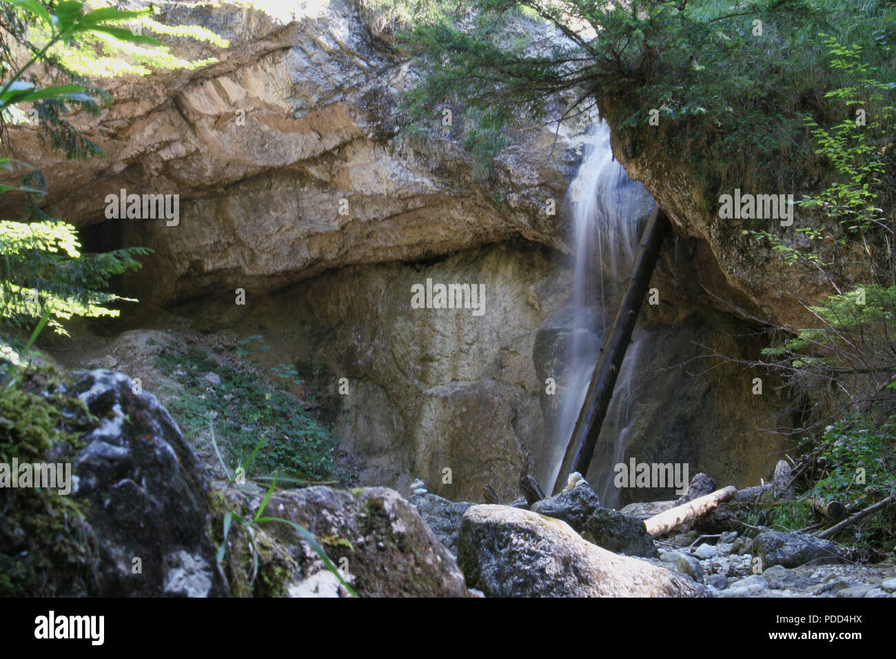 A waterfall off a rock and through the forest Stock Photo - Alamy
