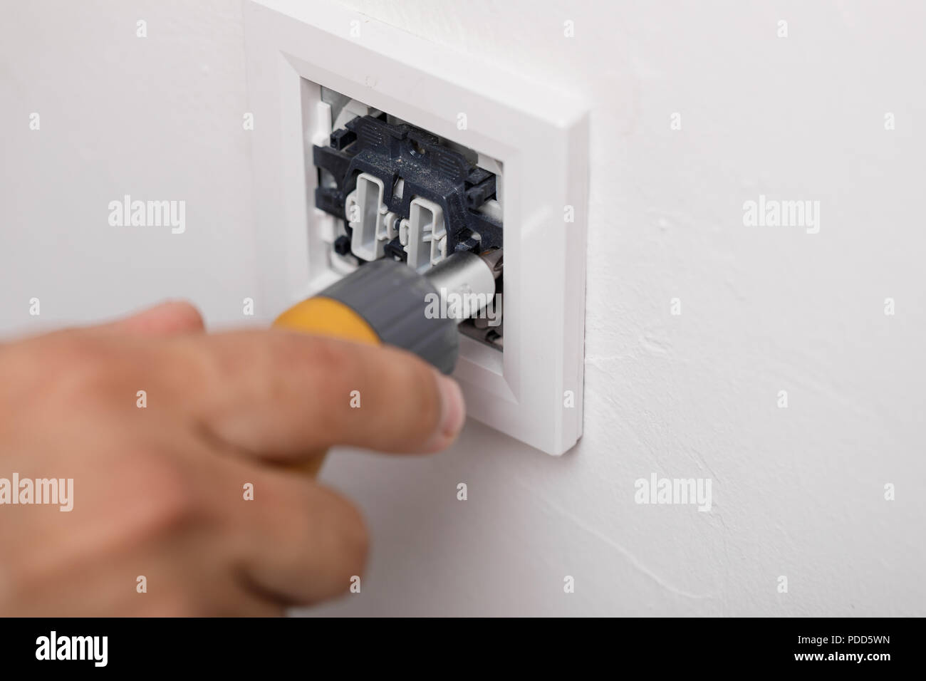 the electrician installing the light switch. tool Stock Photo - Alamy