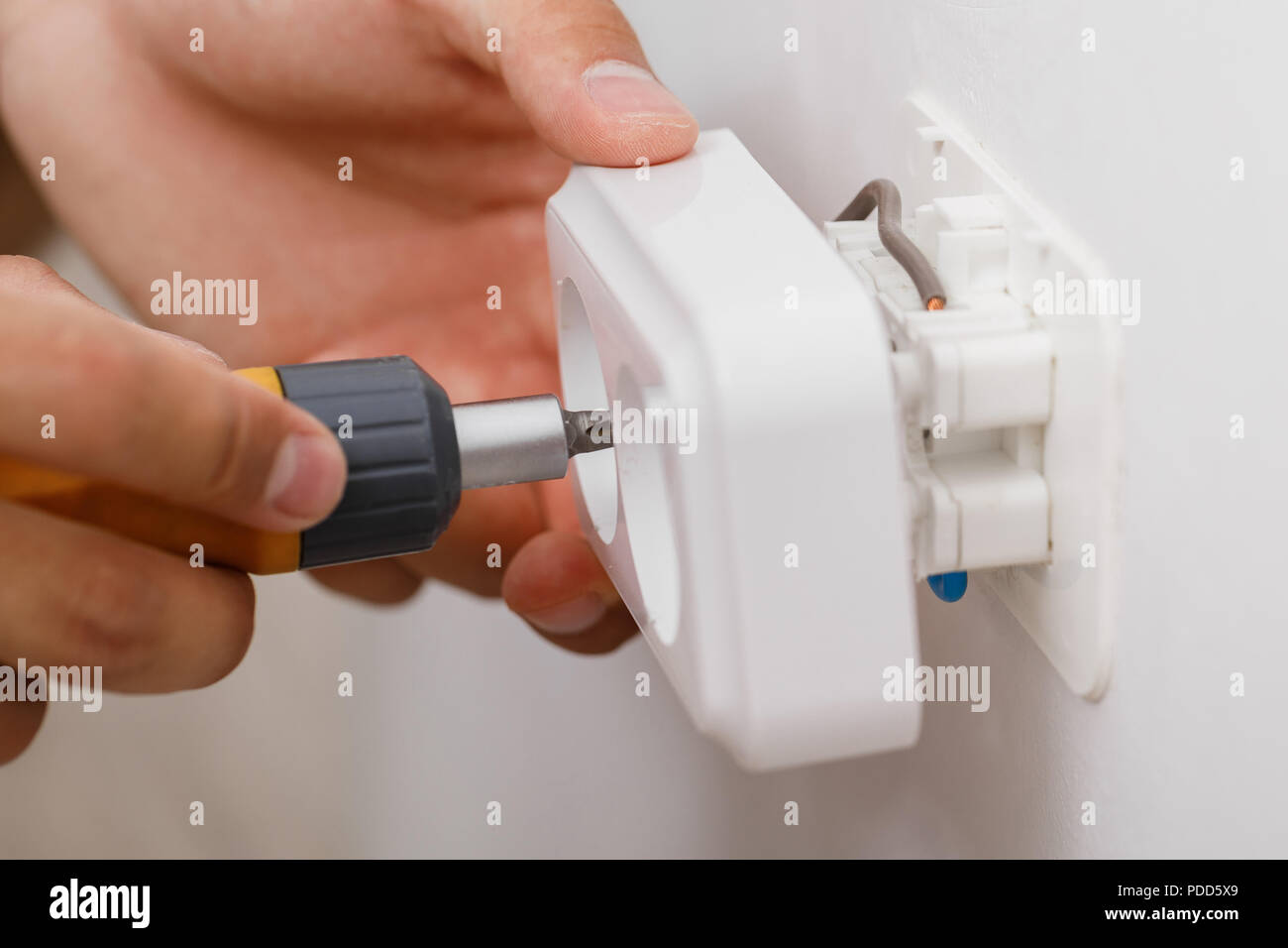 the electrician installing the electrical socket. tool Stock Photo - Alamy