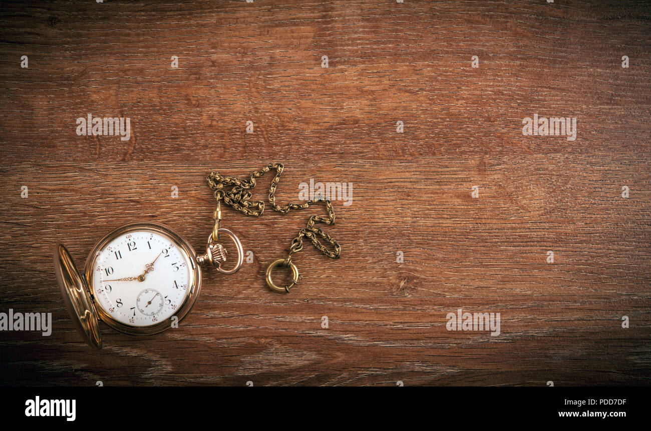 An antique gold pocket watch lies on a wooden table top view Stock ...