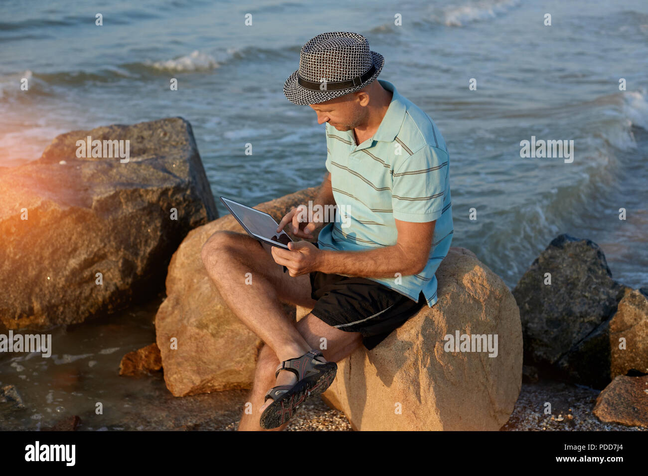 Man working on his laptop on the beach sea, freelancer concept in ...