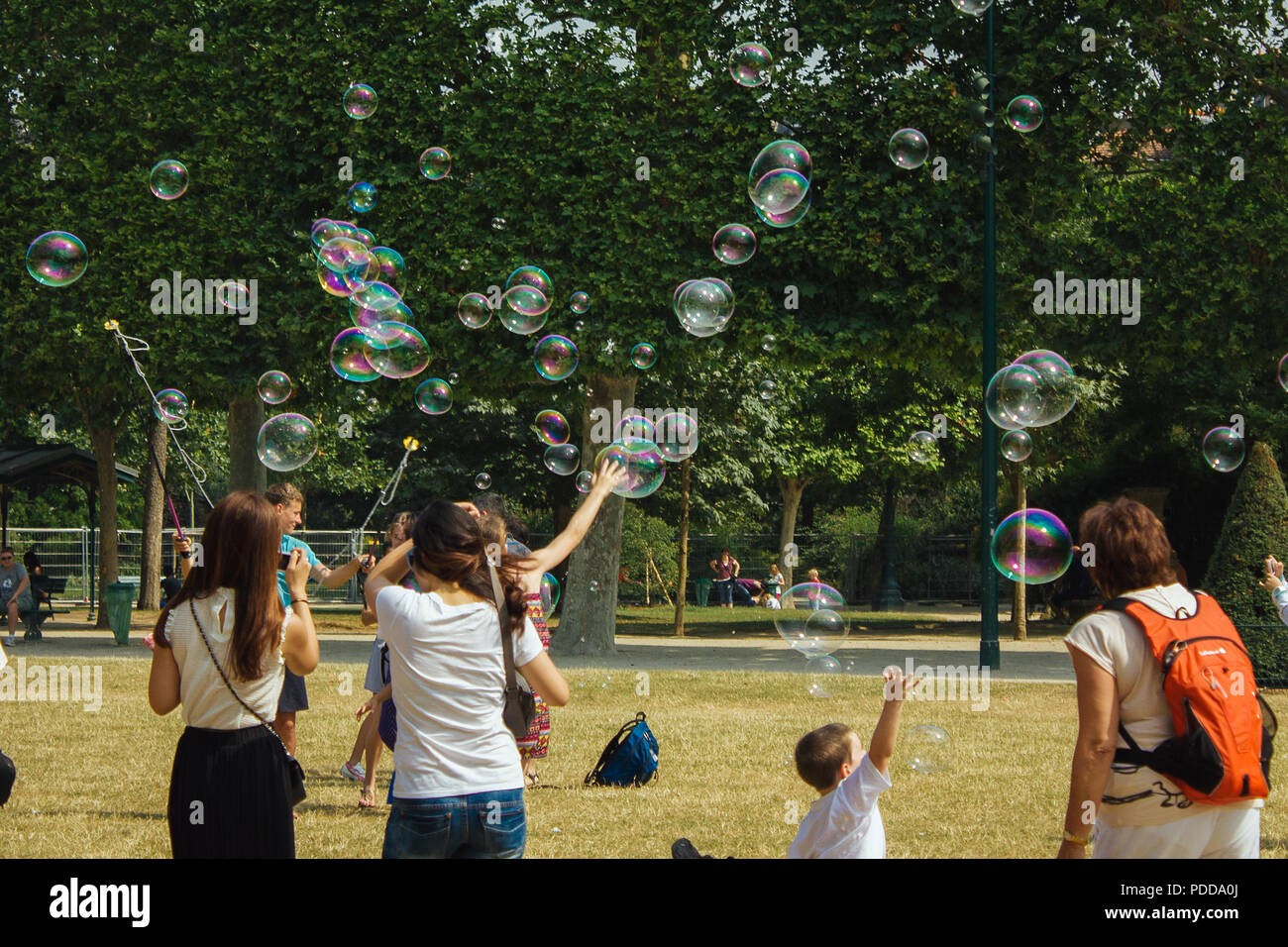 People blowing bubbles in Paris summer Stock Photo - Alamy