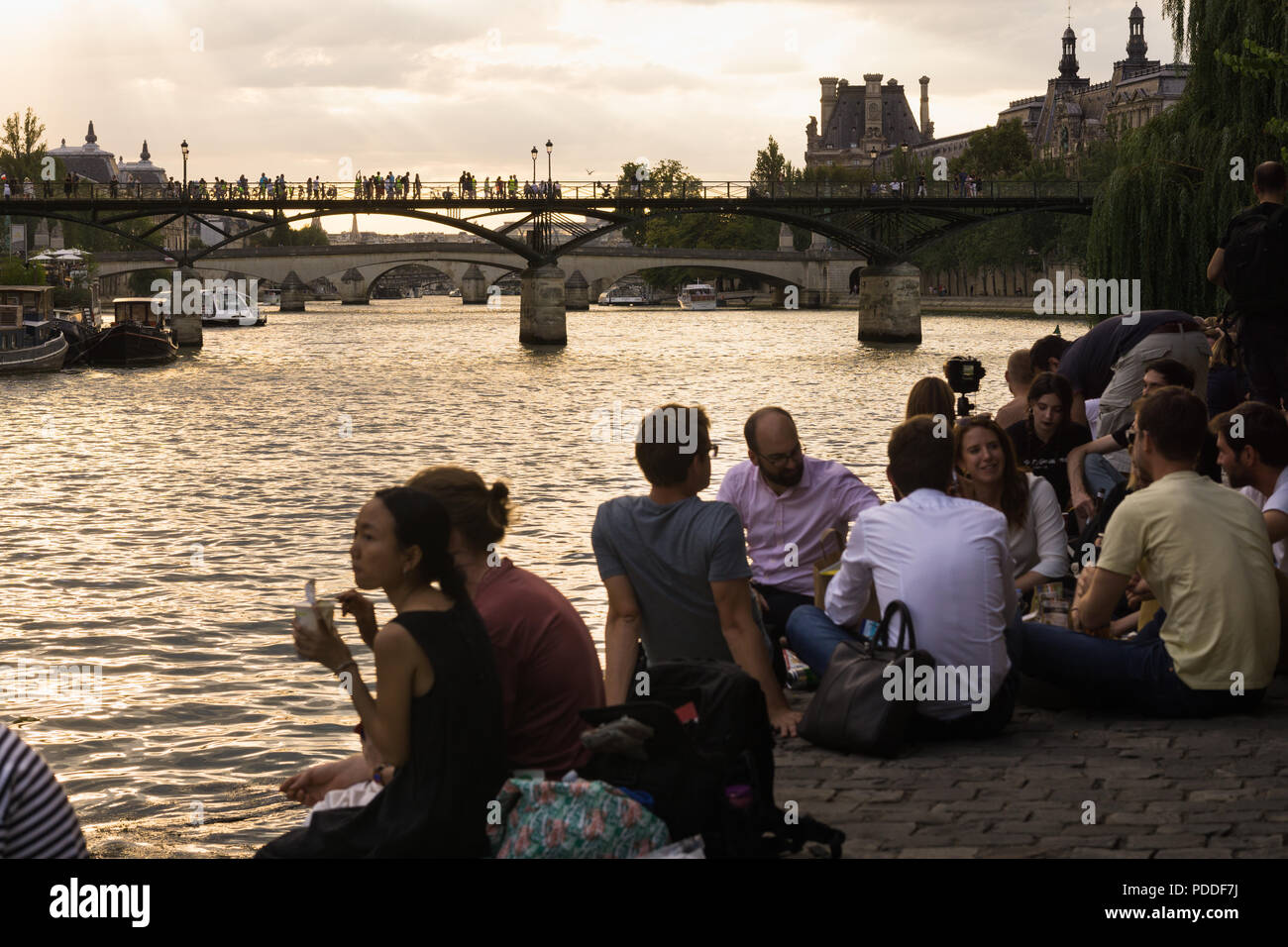 Ile de la Cite at sunset in Paris - People relaxing on the Seine river ...