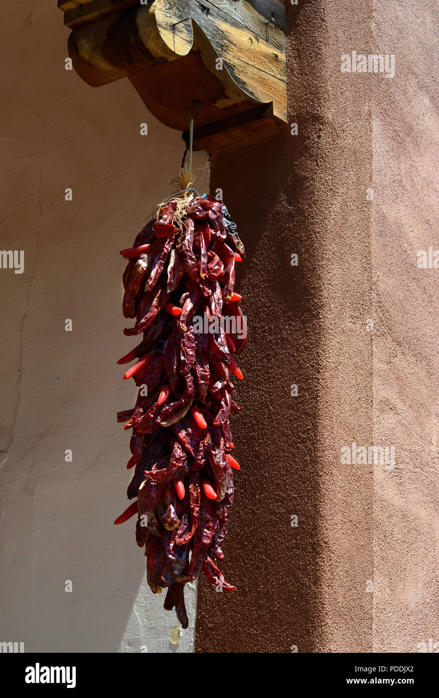 Dried red chili pepper ristras hanging on an adobe wall in Santa Fe ...