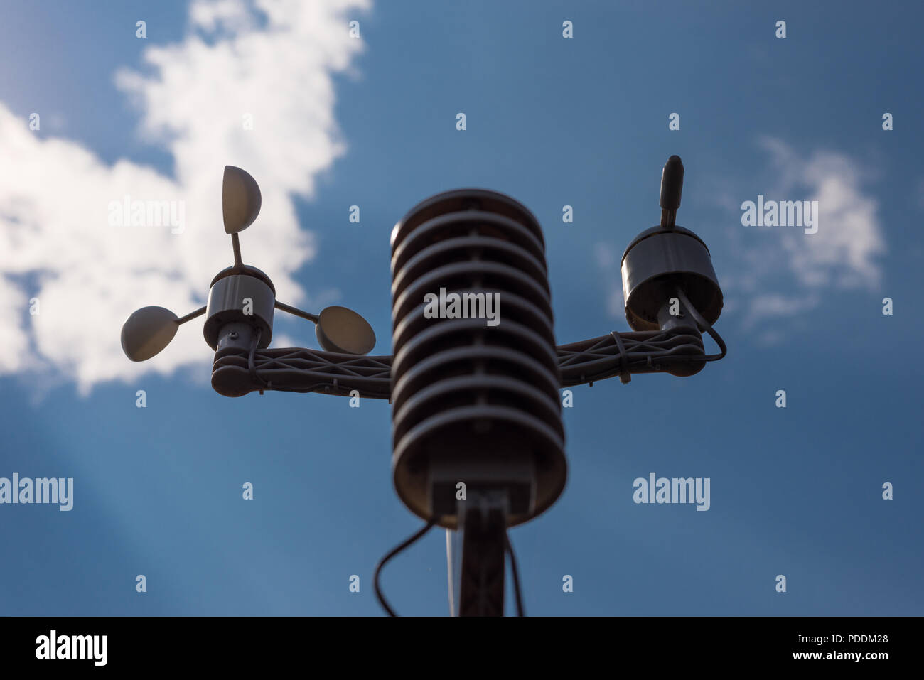 Home weather station on a background of blue sky with the sun behind ...