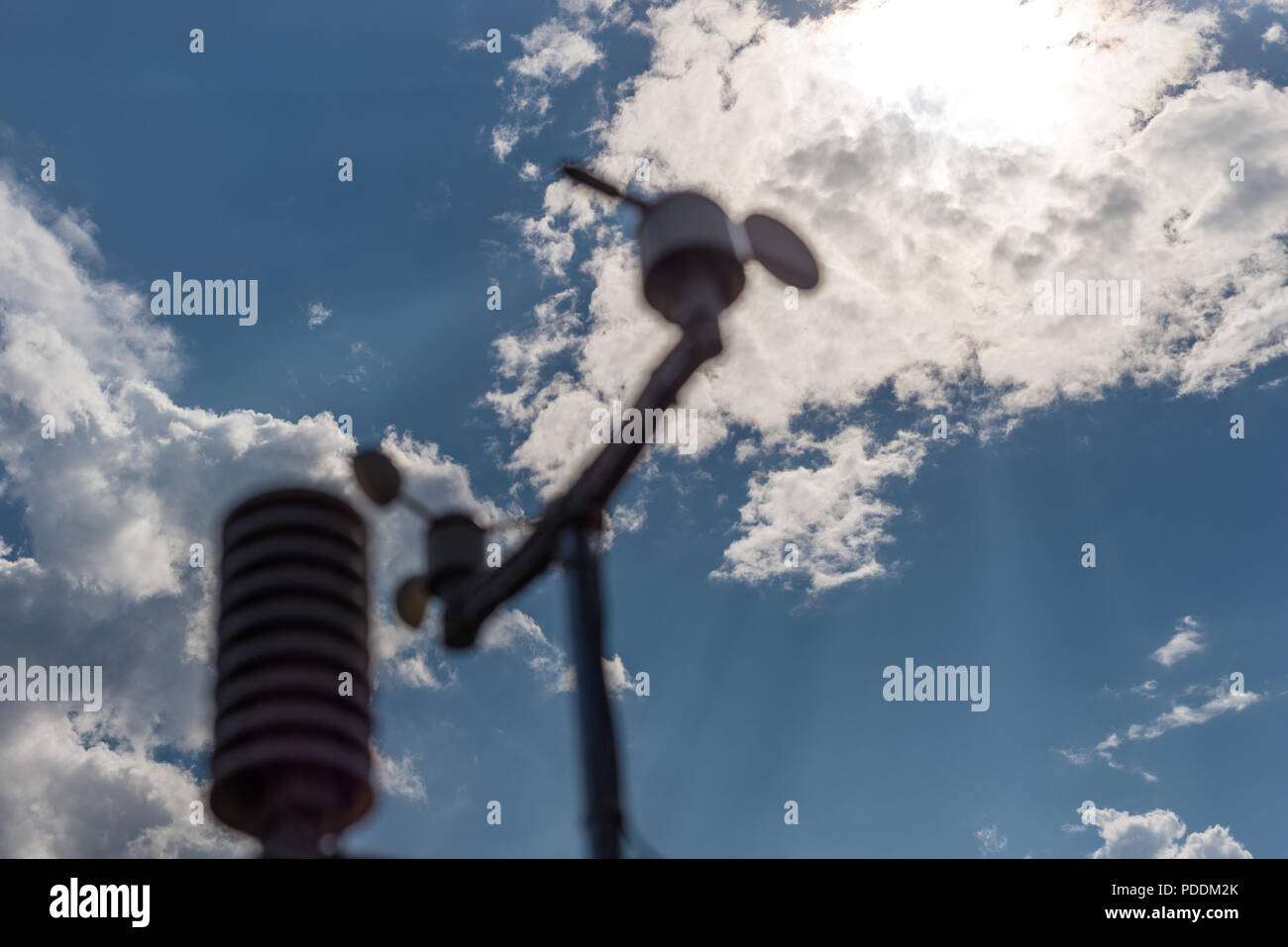 Home weather station on a background of blue sky with the sun behind ...