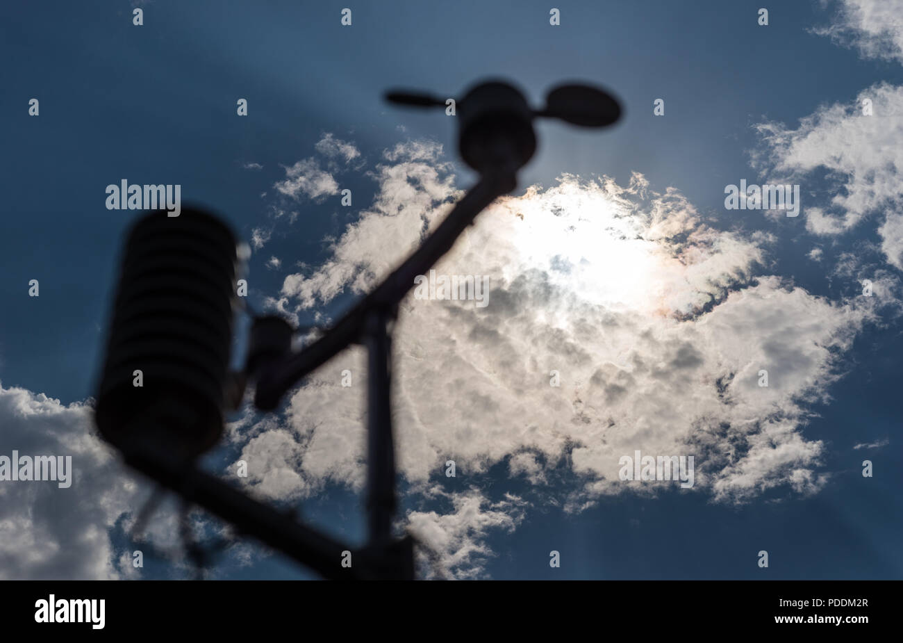Home weather station on a background of blue sky with the sun behind ...