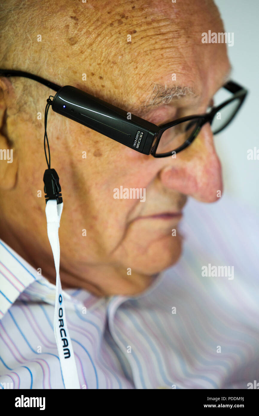 A Pensioner With Macular Degeneration Eyesight Reading Problems Uses An 