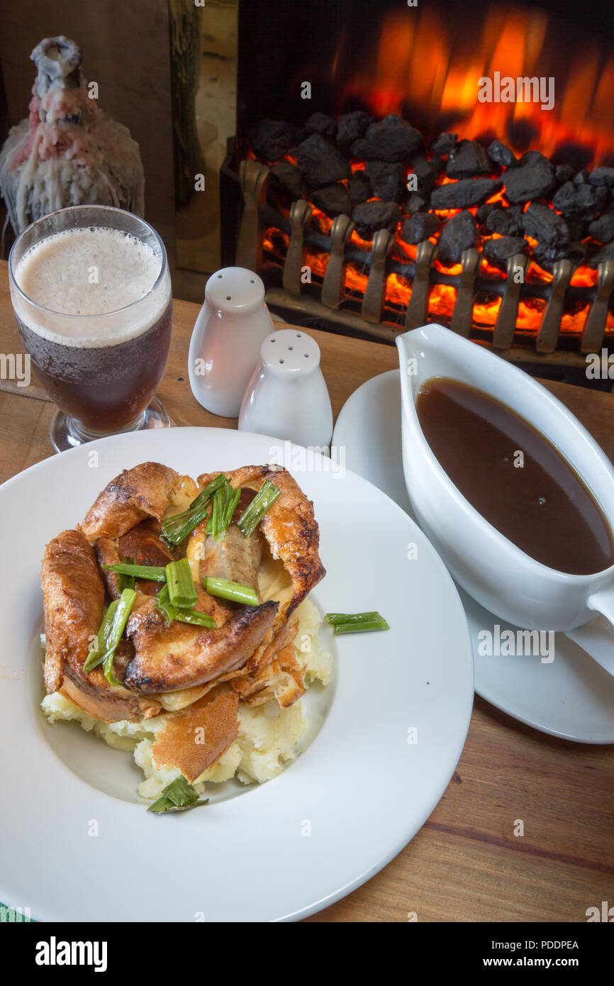 An English pub/restaurant dish of individual Toad in the Hole on a bed ...