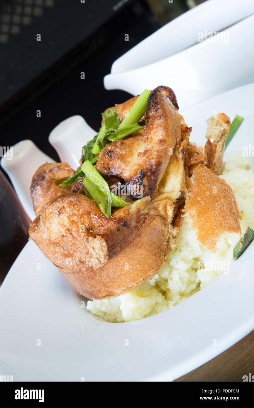 An English pub/restaurant dish of individual Toad in the Hole on a bed ...