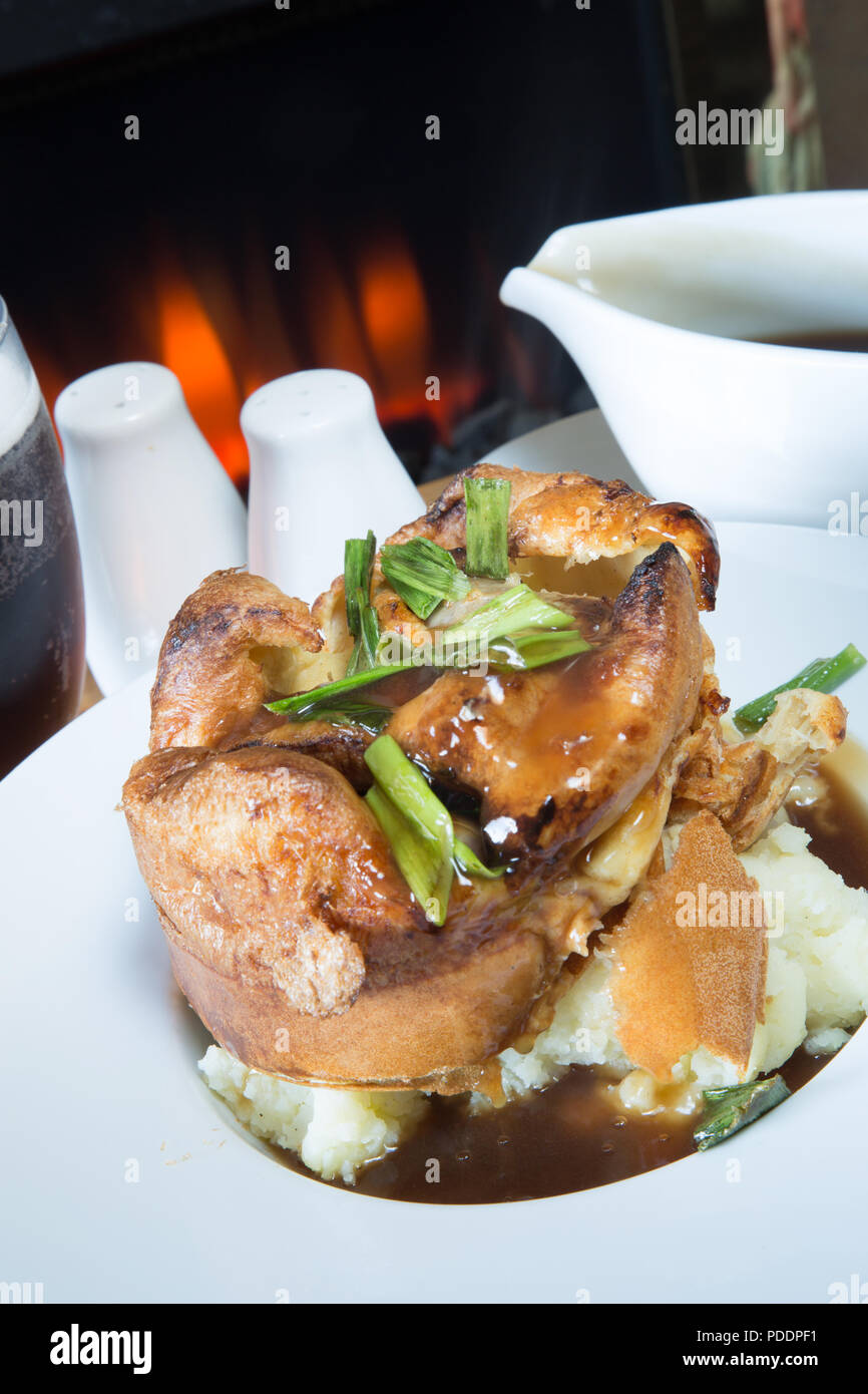 An English pub/restaurant dish of individual Toad in the Hole on a bed ...