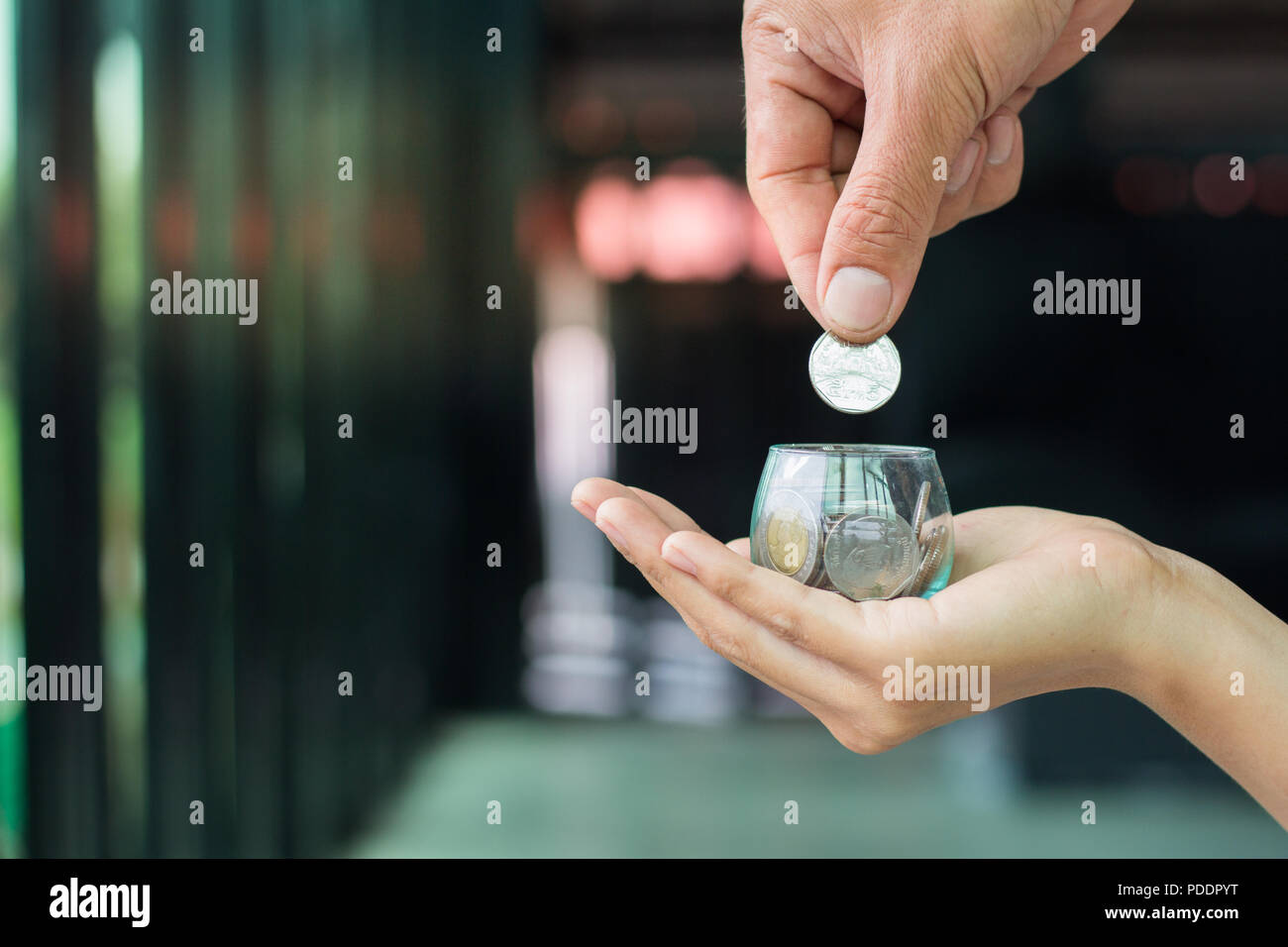 Hand putting coin glass jar hi-res stock photography and images - Alamy