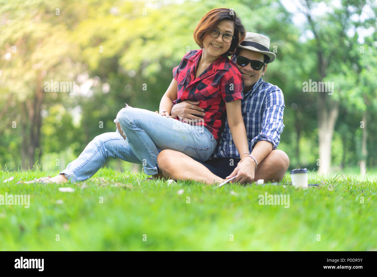 female sitting on man lap in green park happy couple Stock Photo - Alamy