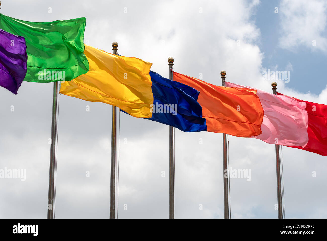Various single-colour flags flying from a row of flag poles in Shanghai ...