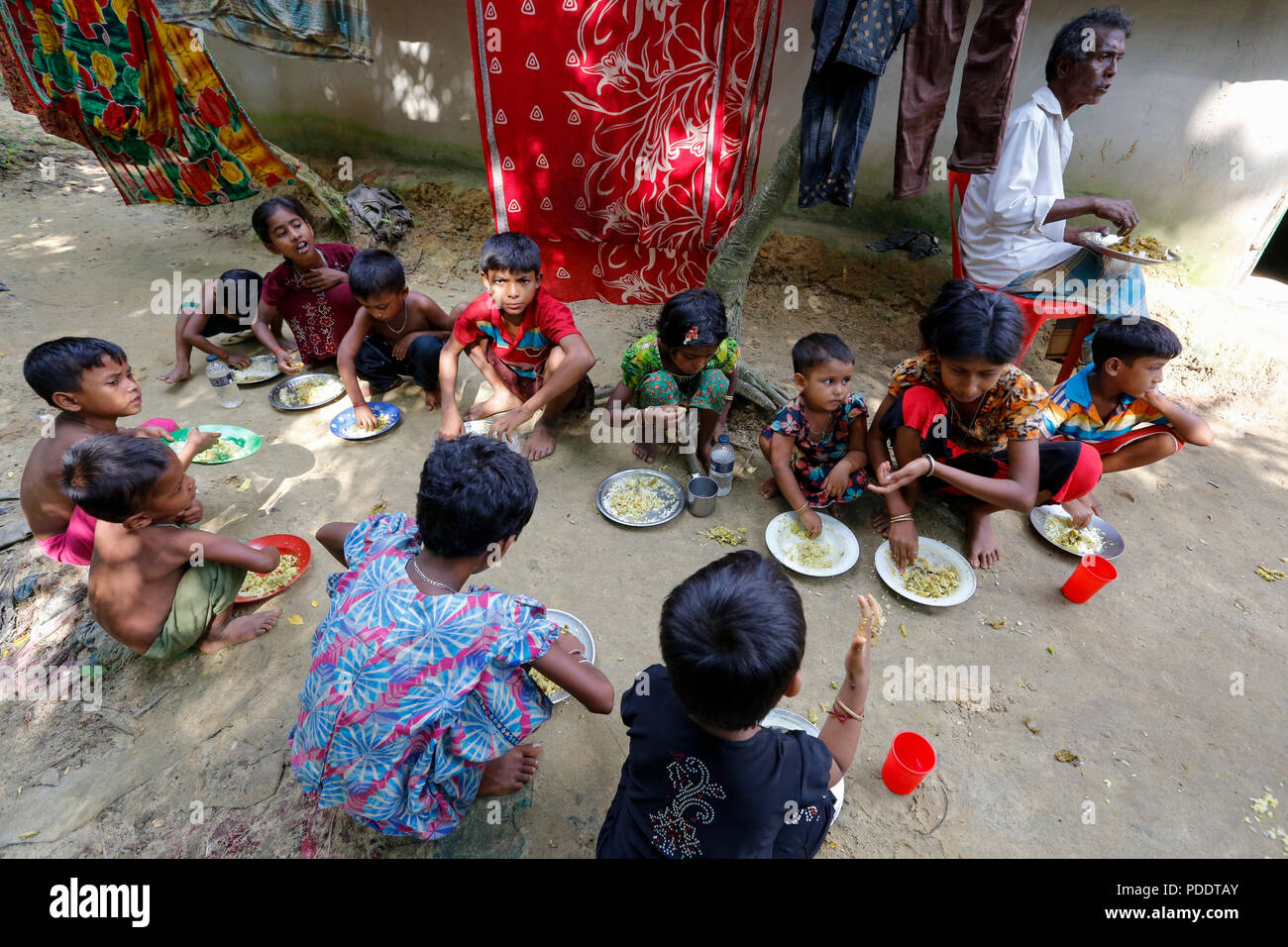 Children eat their meals at a temporary refugee camp at Kutupalong in ...
