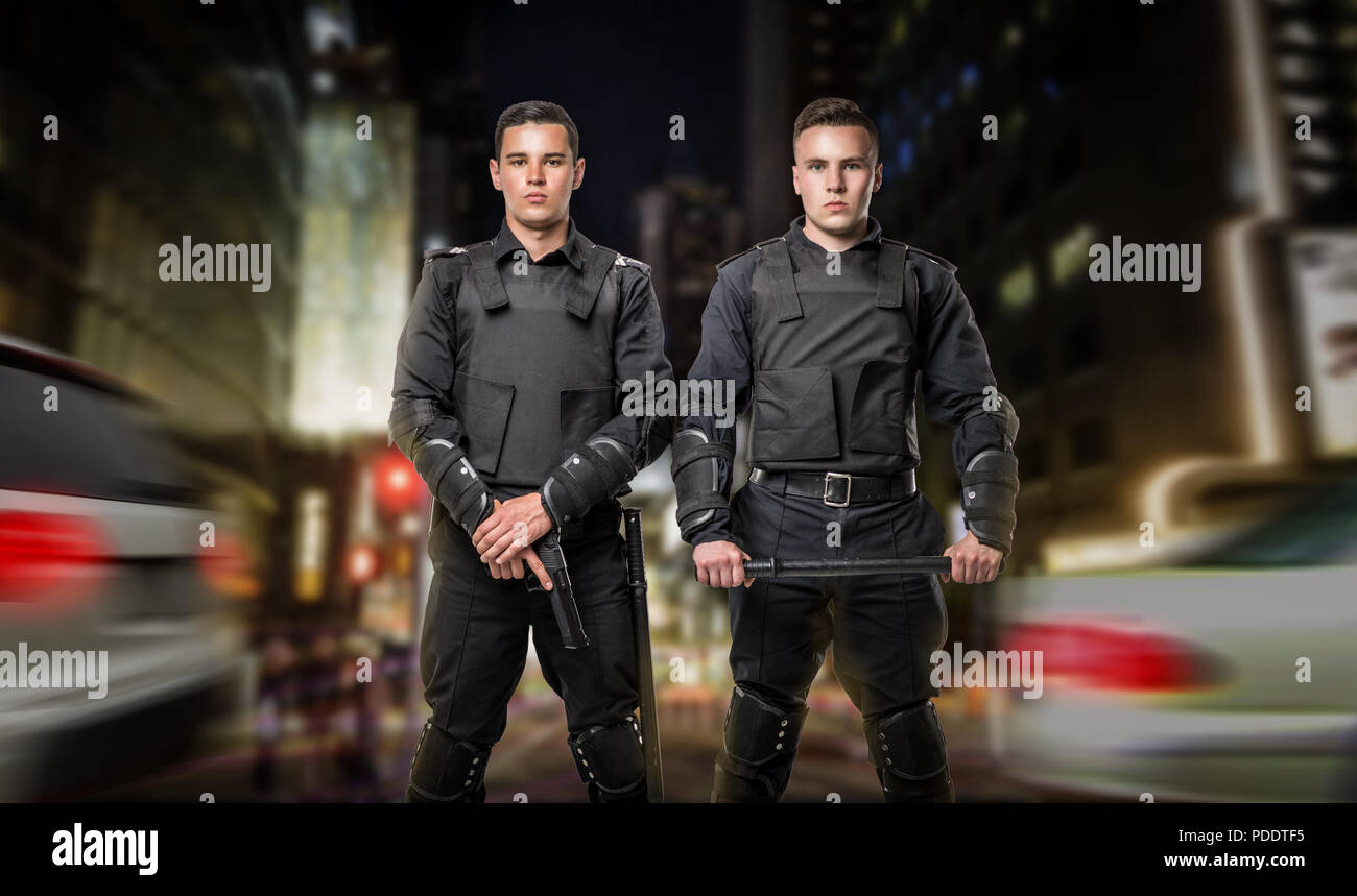 Cops with gun and a baton on guard of law Stock Photo - Alamy
