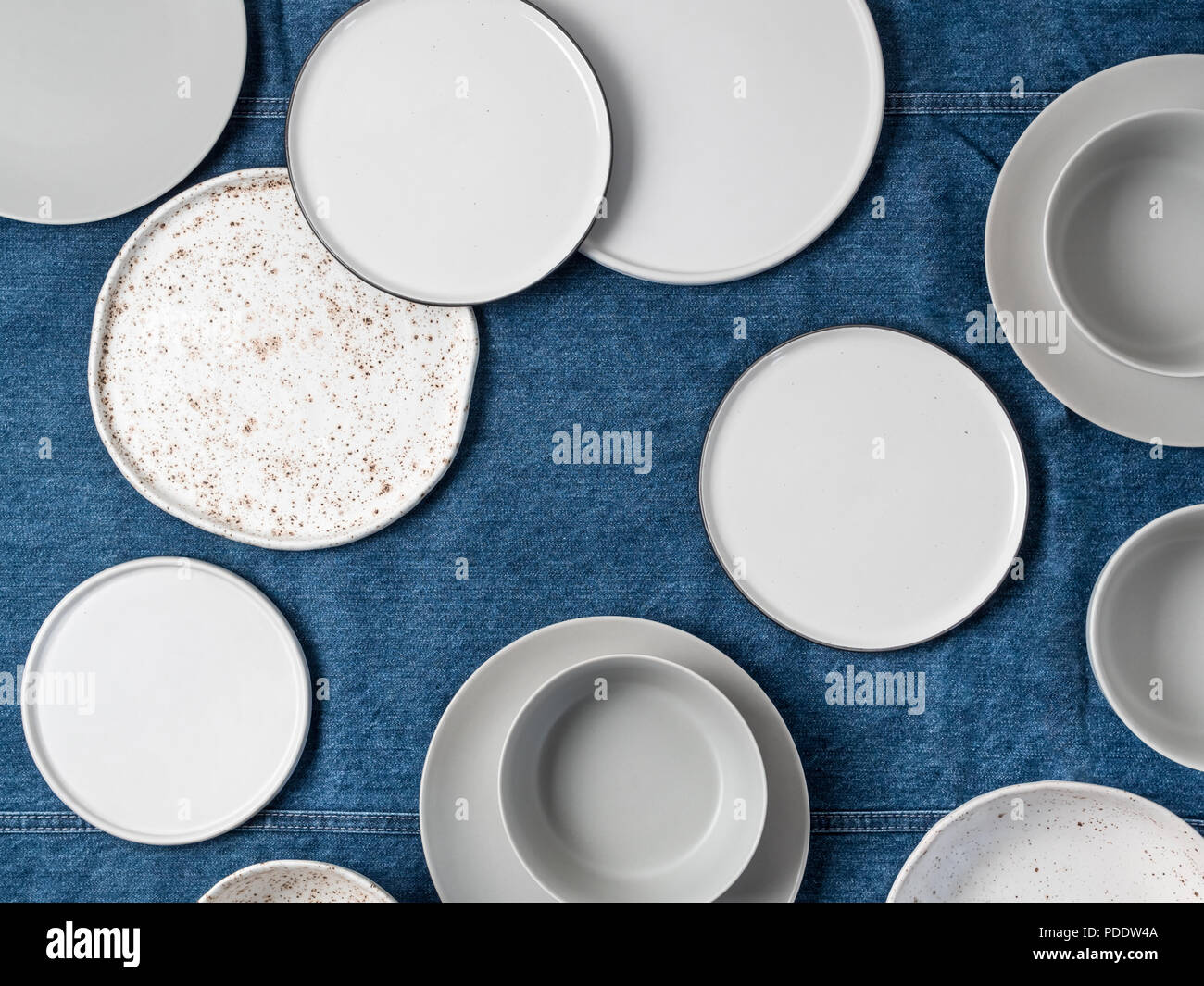 Empty ceramic tableware. Ceramic plates on jeans tablecloth or runner ...