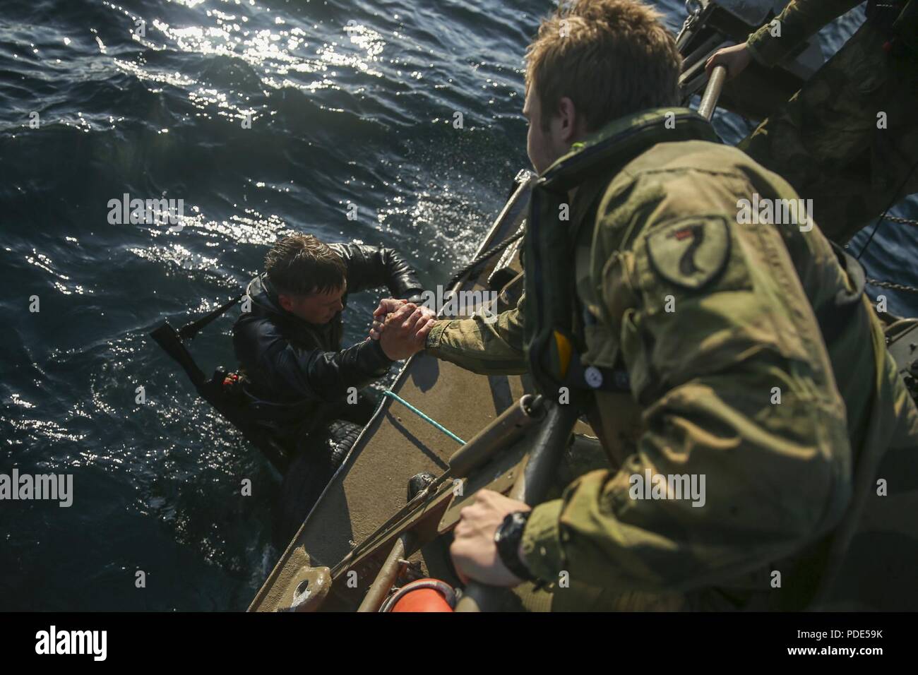 A Norwegian Coastal Ranger Commando (KJK), right, helps a U.S. Marine ...