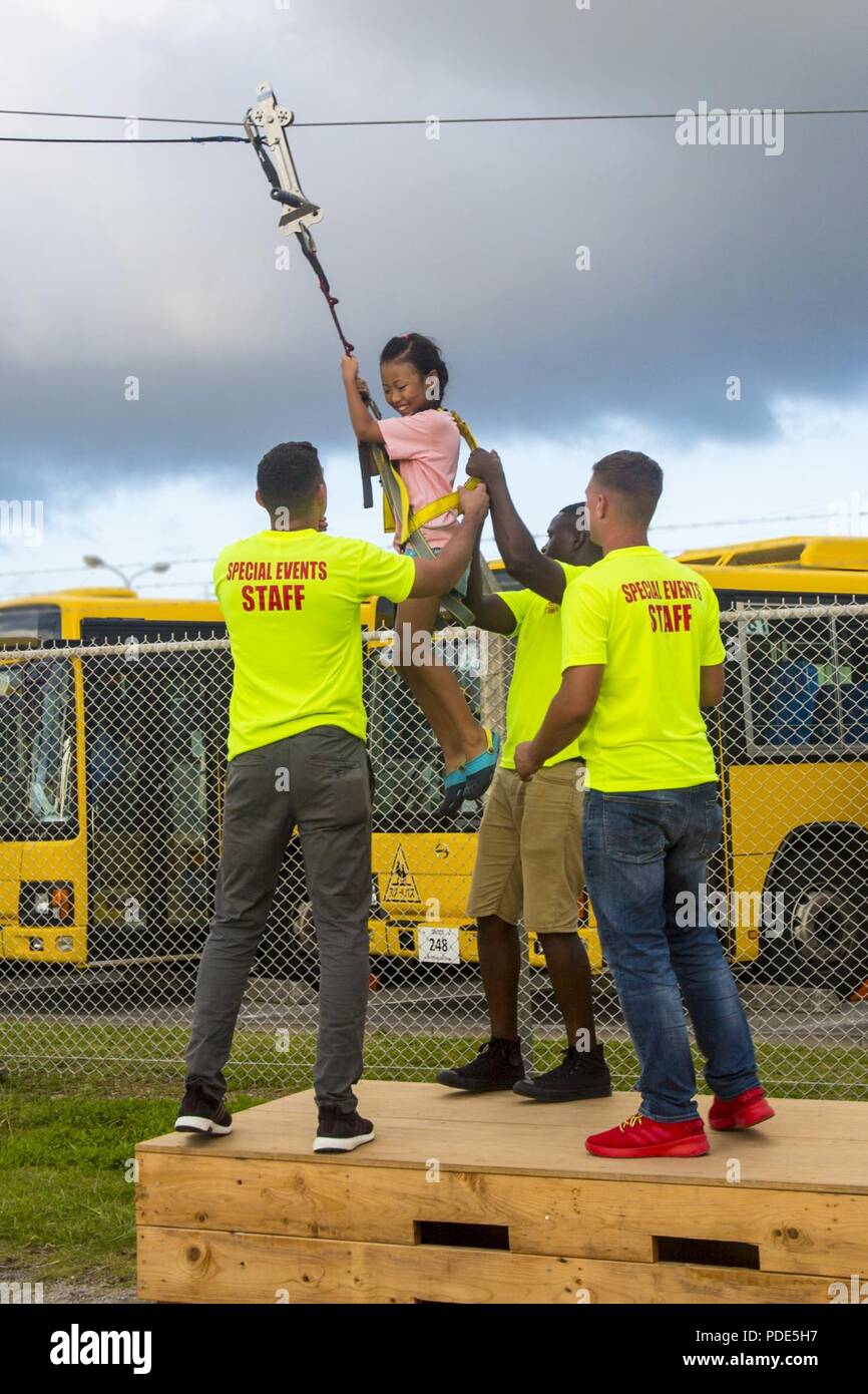 CAMP FOSTER, OKINAWA, Japan – Volunteers help a child down from a zip ...