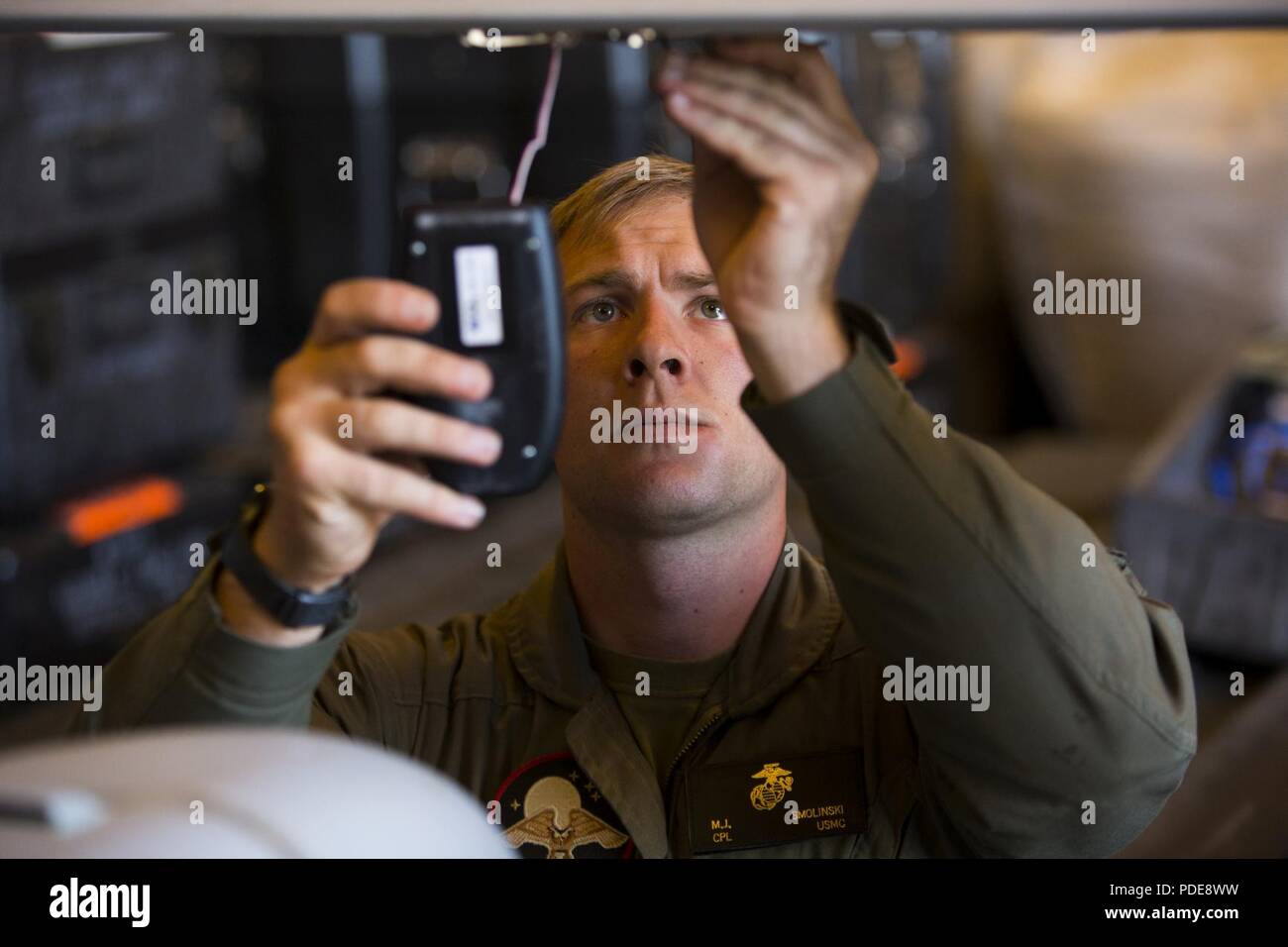U.S. Marine Corps Cpl. Michael J. Smolinski conducts maintenance on a ...