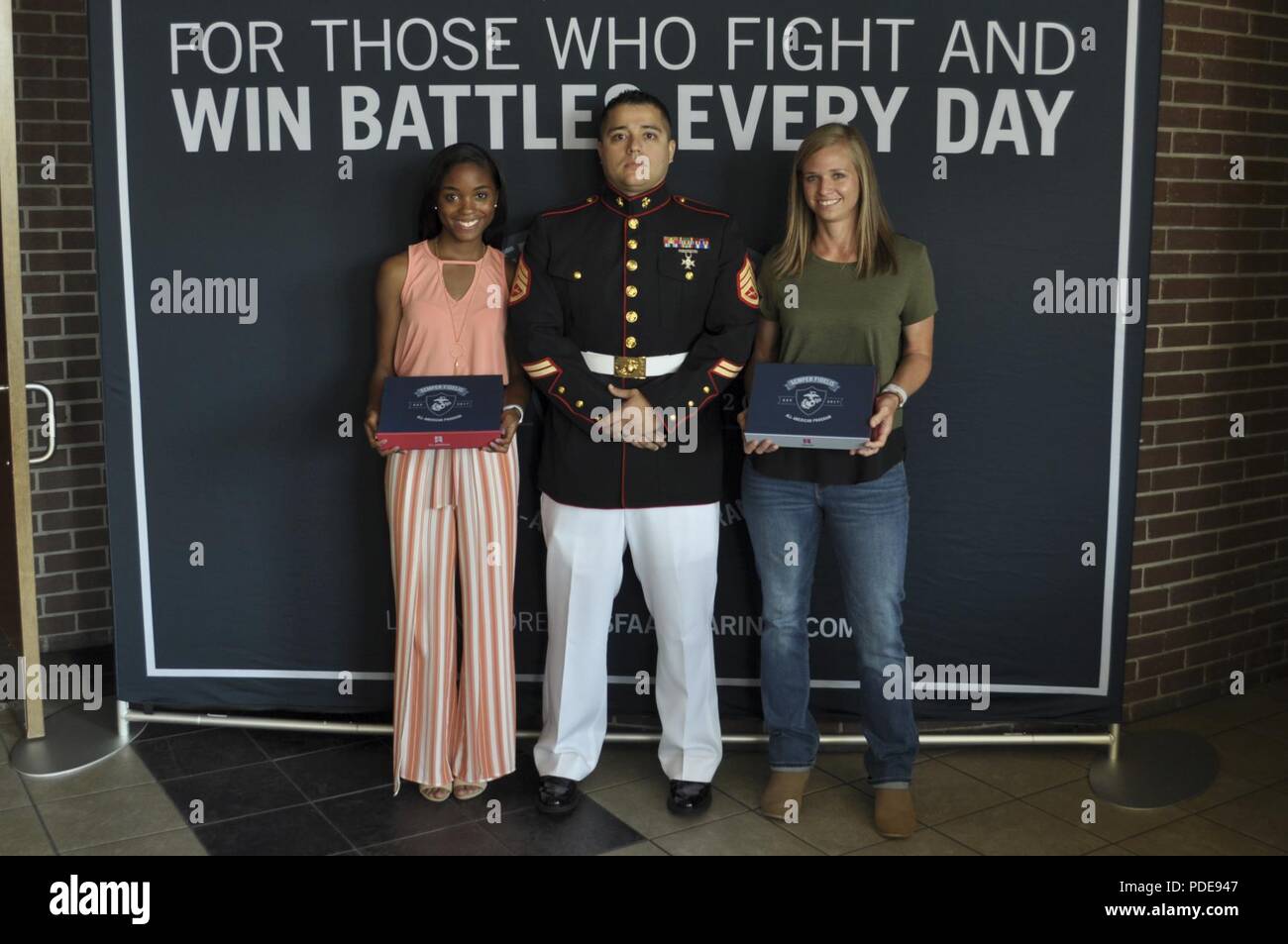 U.S. Marine Staff Sgt. John Harris presents Katelyn Cartwright (left ...