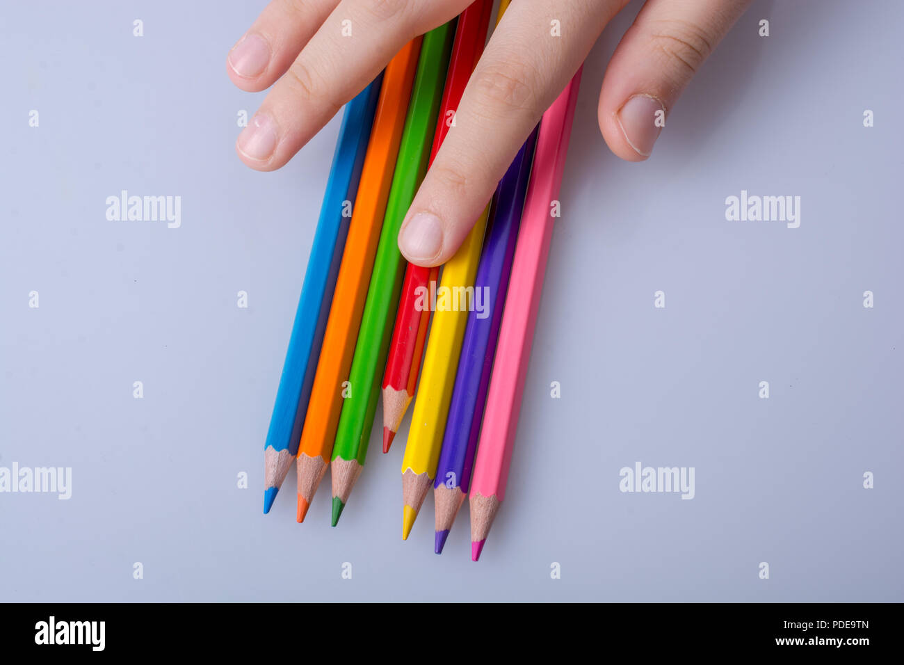 Hand holding color Pencils placed on a white background Stock Photo - Alamy