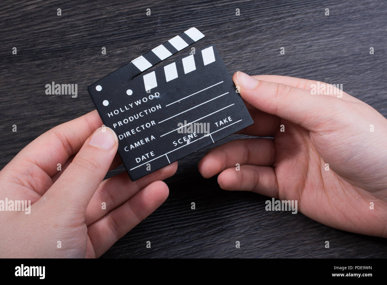 Hand holding movie clapper on a dark background Stock Photo - Alamy