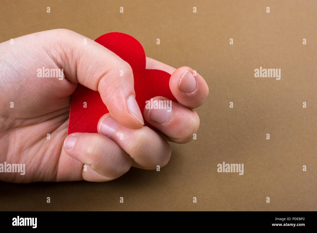 Red color heart shaped object in hand on dotted paper Stock Photo - Alamy