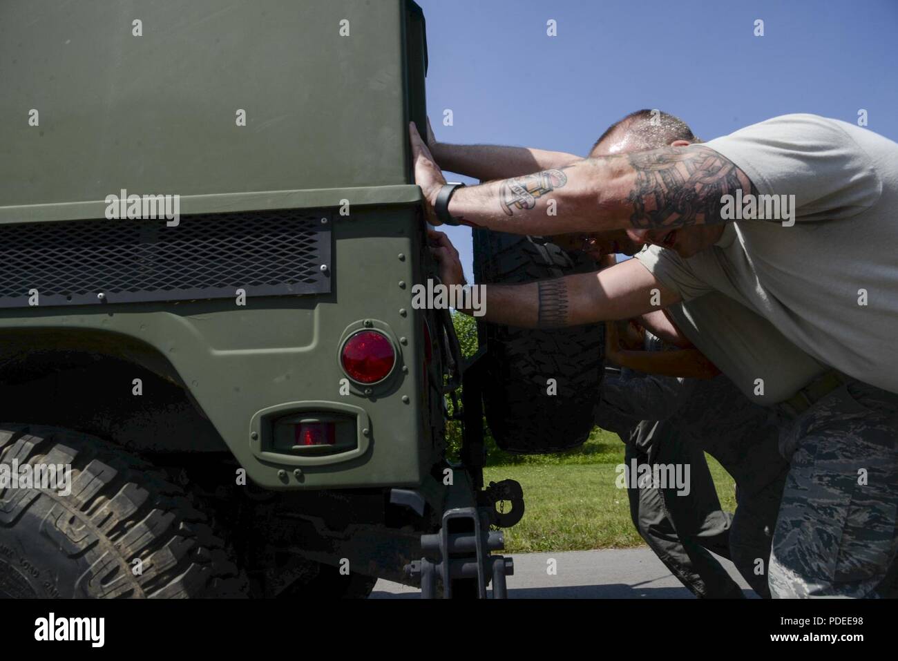 Atlantic Stripe Conference participants push a humvee as part of an ...