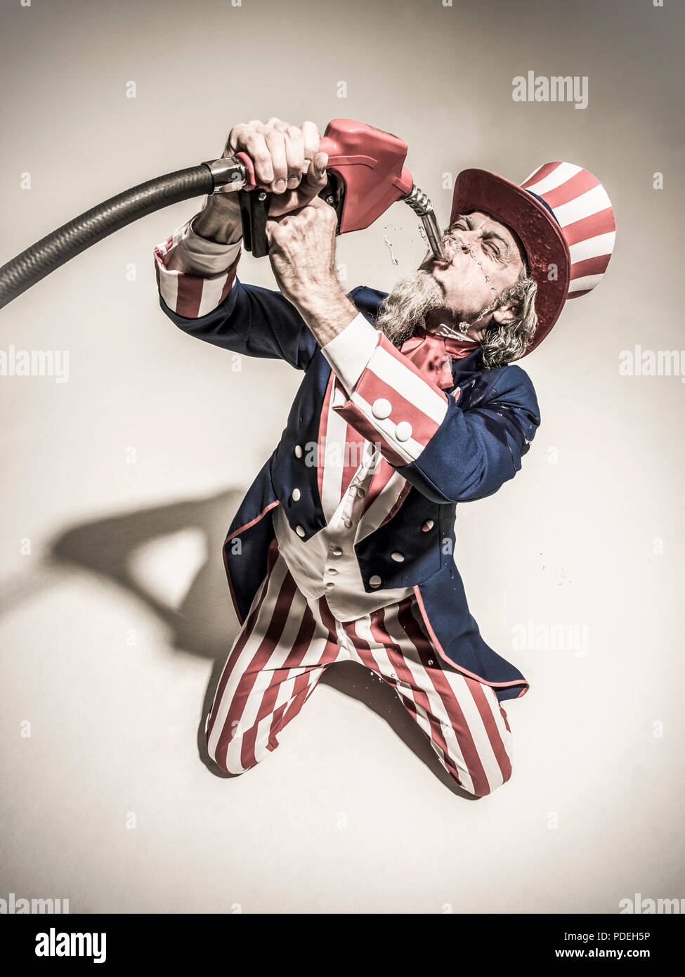 Uncle Sam sucking gasoline from a gas pump nozzle. Addicted to oil / fossil fuels Stock Photo ...