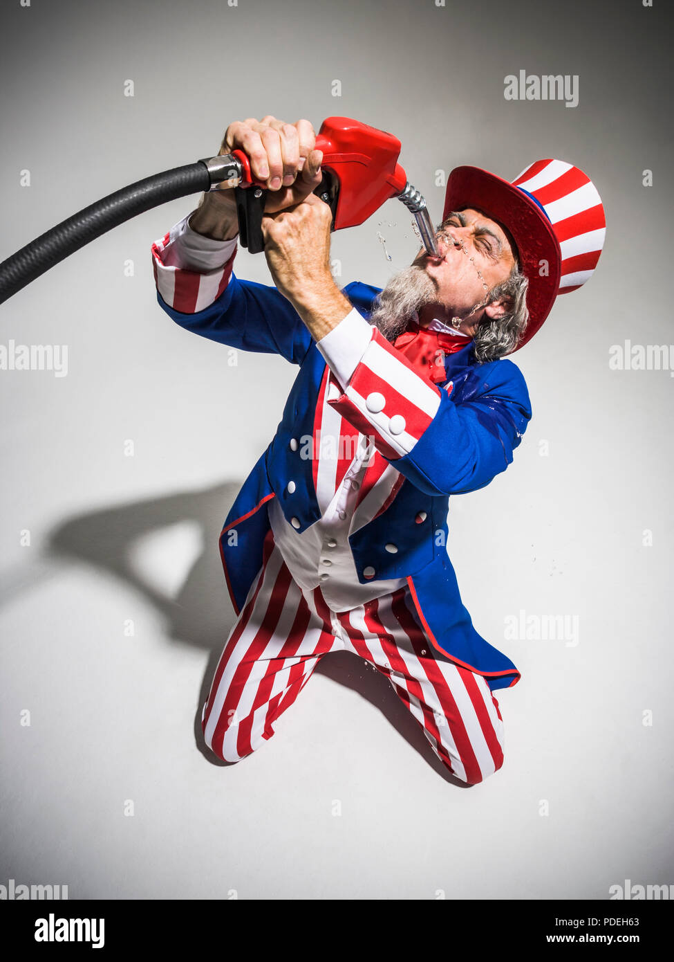 Uncle Sam sucking gasoline from a gas pump nozzle. Addicted to oil ...