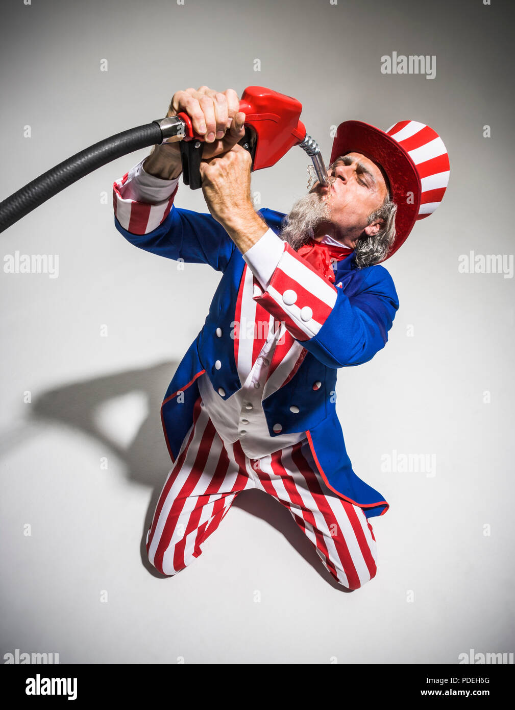 Uncle Sam sucking gasoline from a gas pump nozzle. Addicted to oil ...