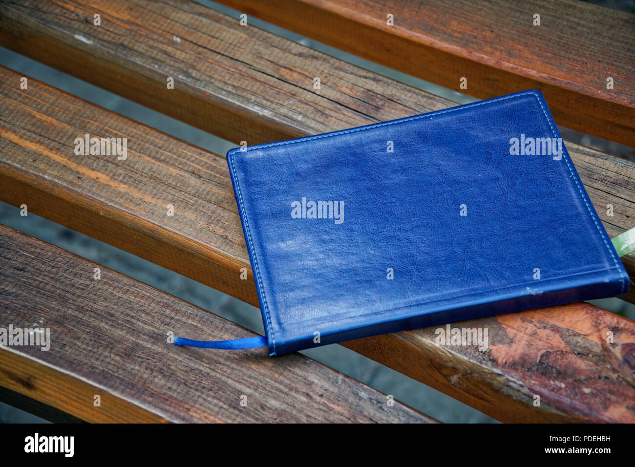Notebook on bench in park, business concept Stock Photo - Alamy