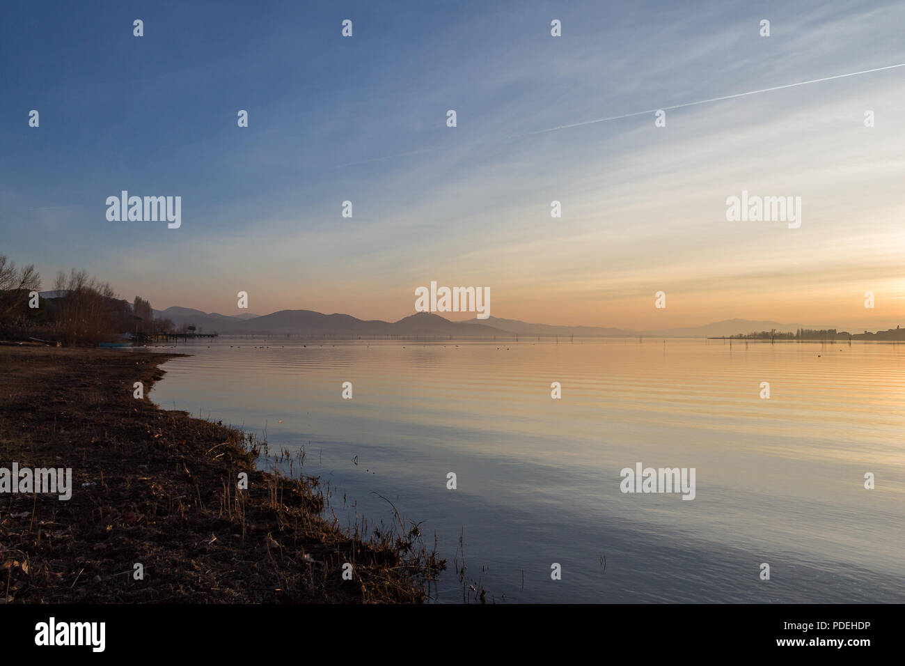 A shoot of a sunset over a lake, with beautiful warm colors and many ...