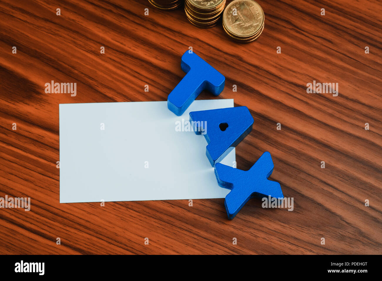 TAX concept. TAX alphabet with stack of coin and business card or name ...