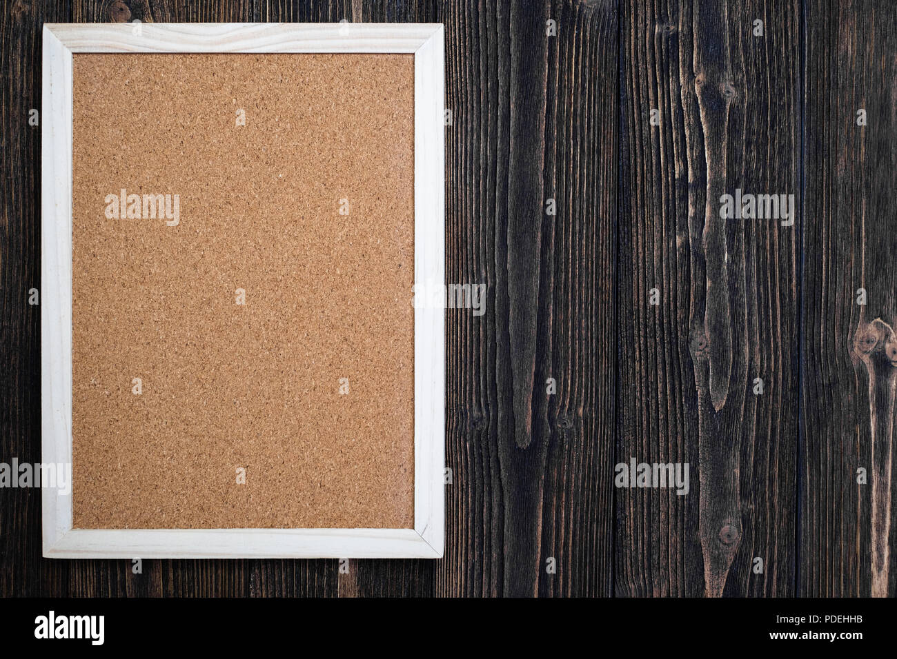 Empty cork board with wooden frame on wooden desk, top view with copy ...