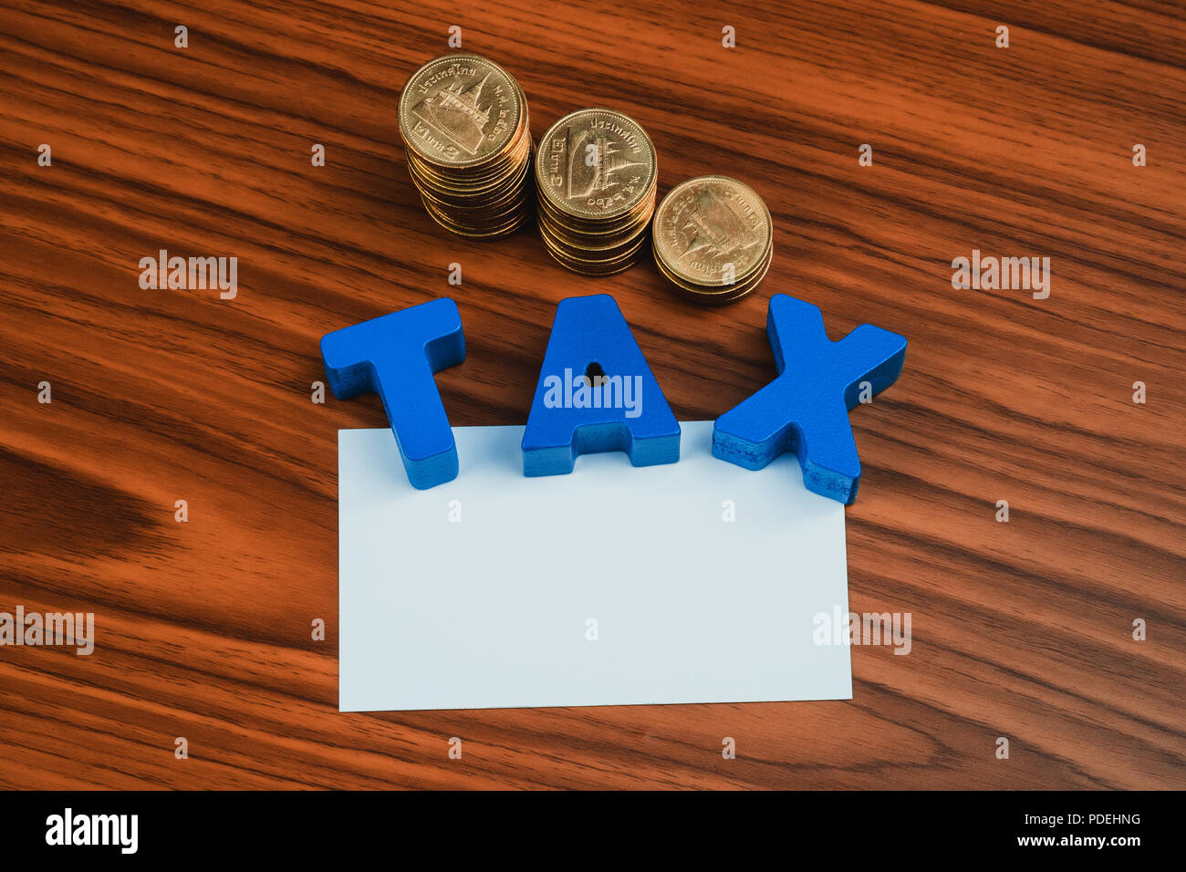 TAX concept. TAX alphabet with stack of coin and business card or name ...